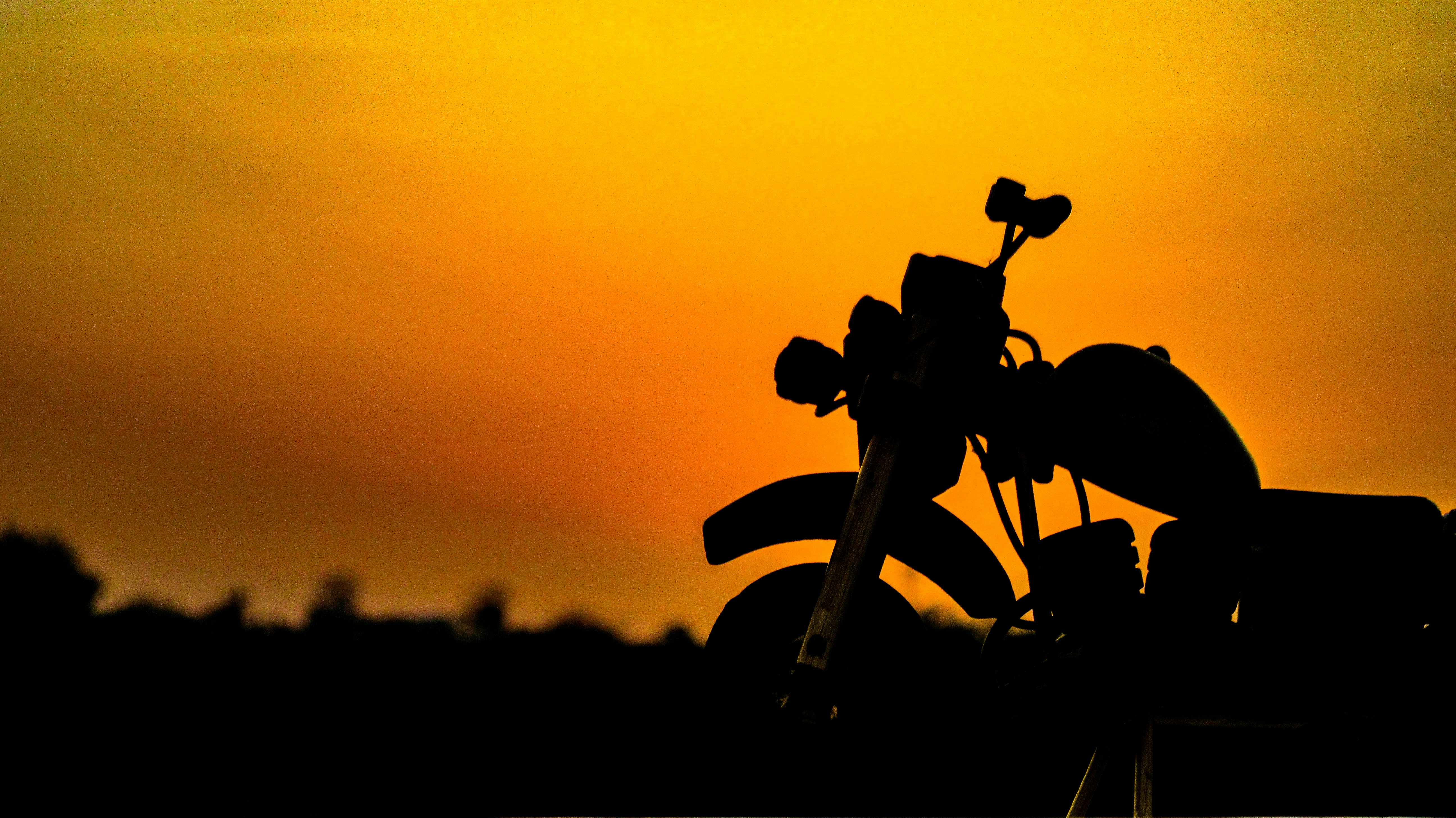 Silhouette of a motorcycle against a vibrant sunset, capturing the essence of adventure and freedom.