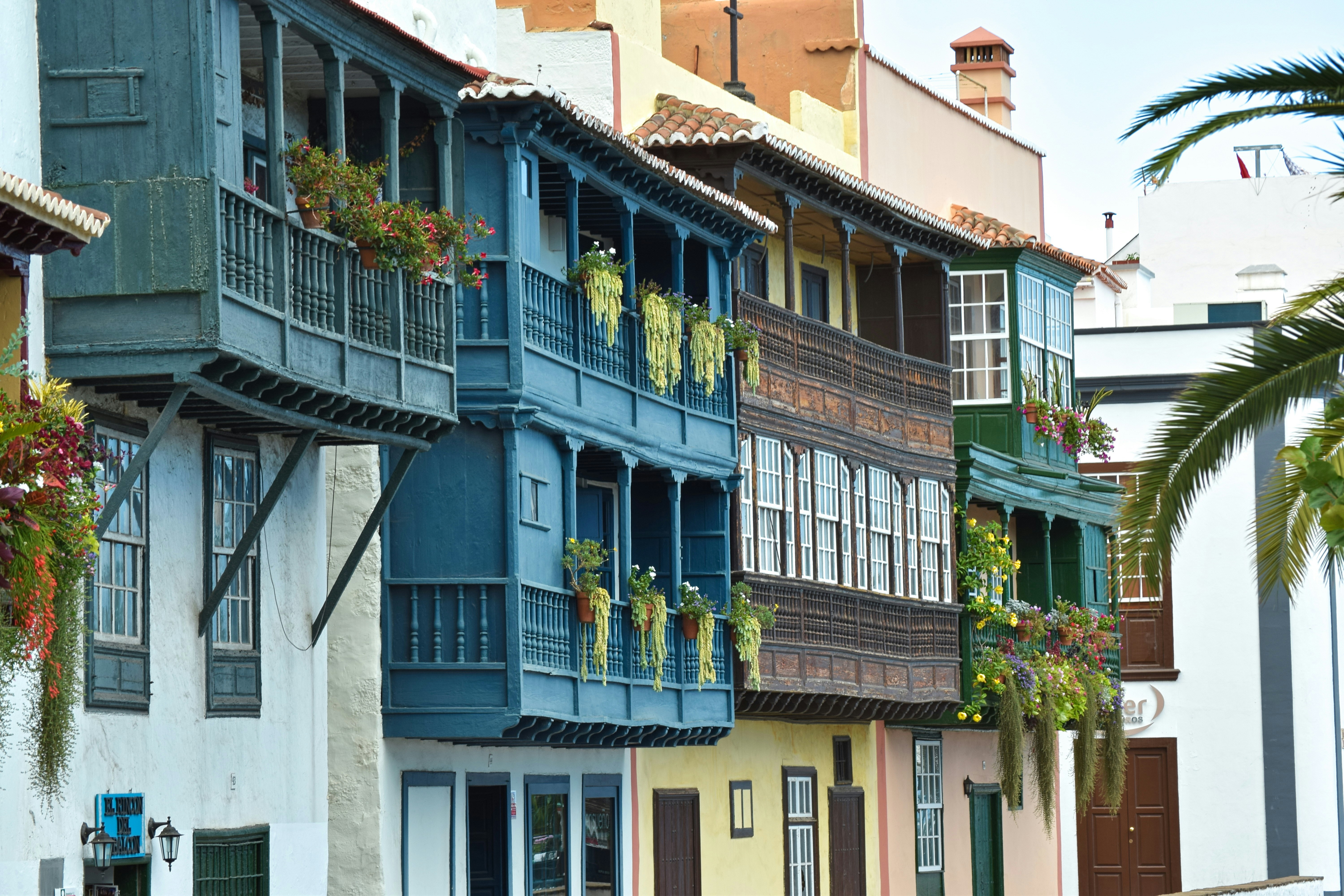 Vibrant colonial-style balconies adorned with flowers, showcasing the rich architectural heritage of the region.