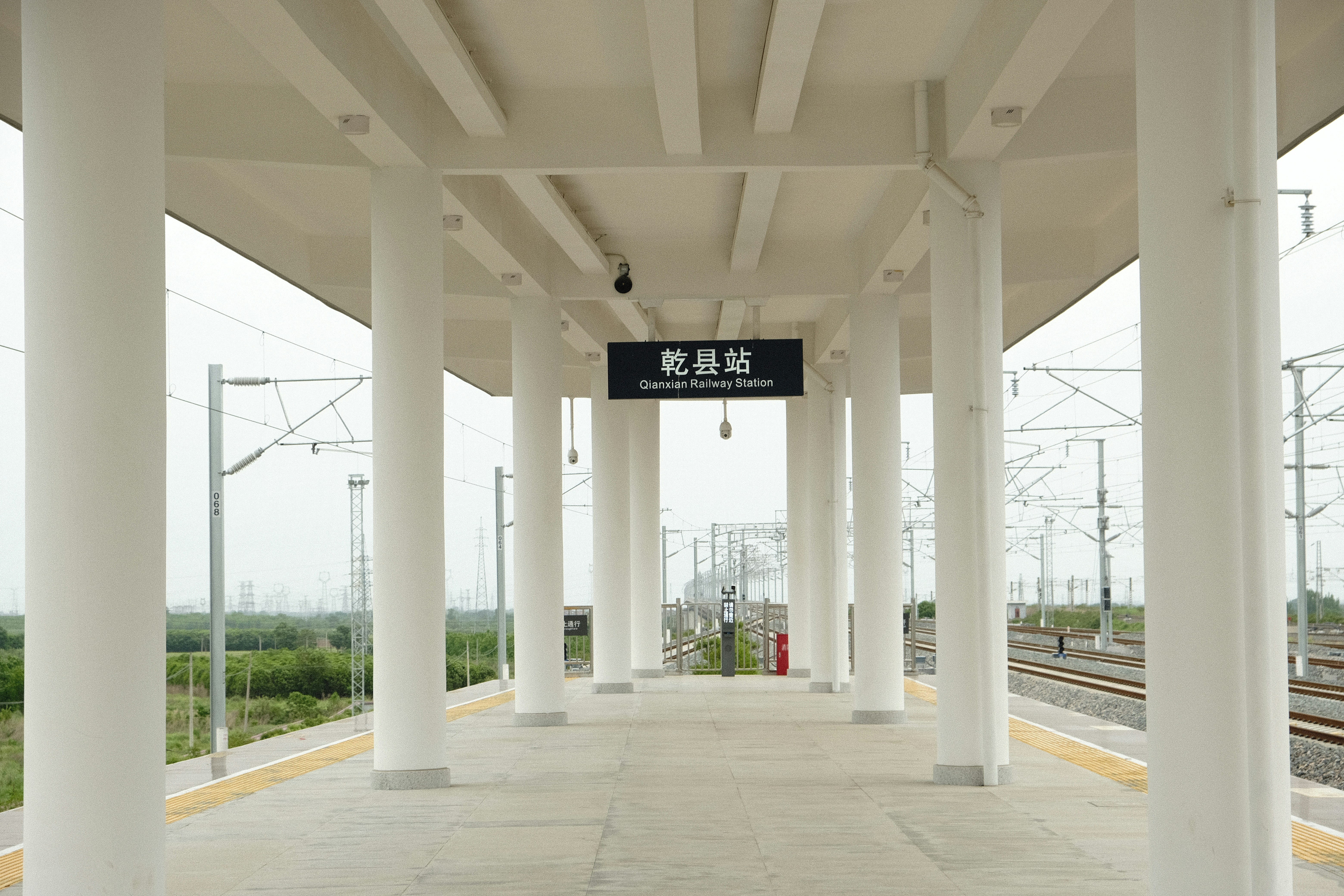 A train station with white pillars and a black sign photo – Free City ...