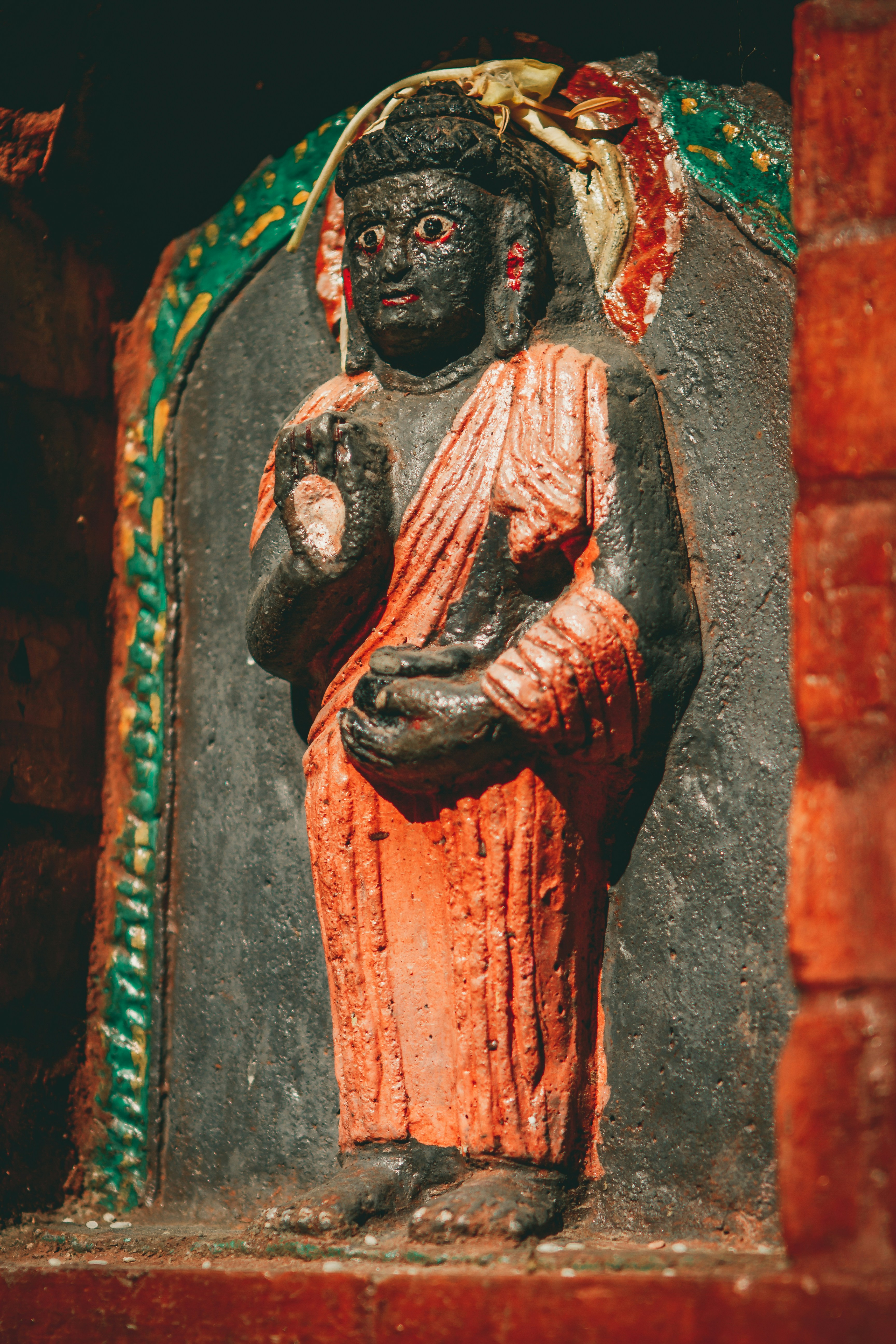 Intricately carved statue of a deity adorned with colorful details, showcasing traditional craftsmanship and cultural significance.