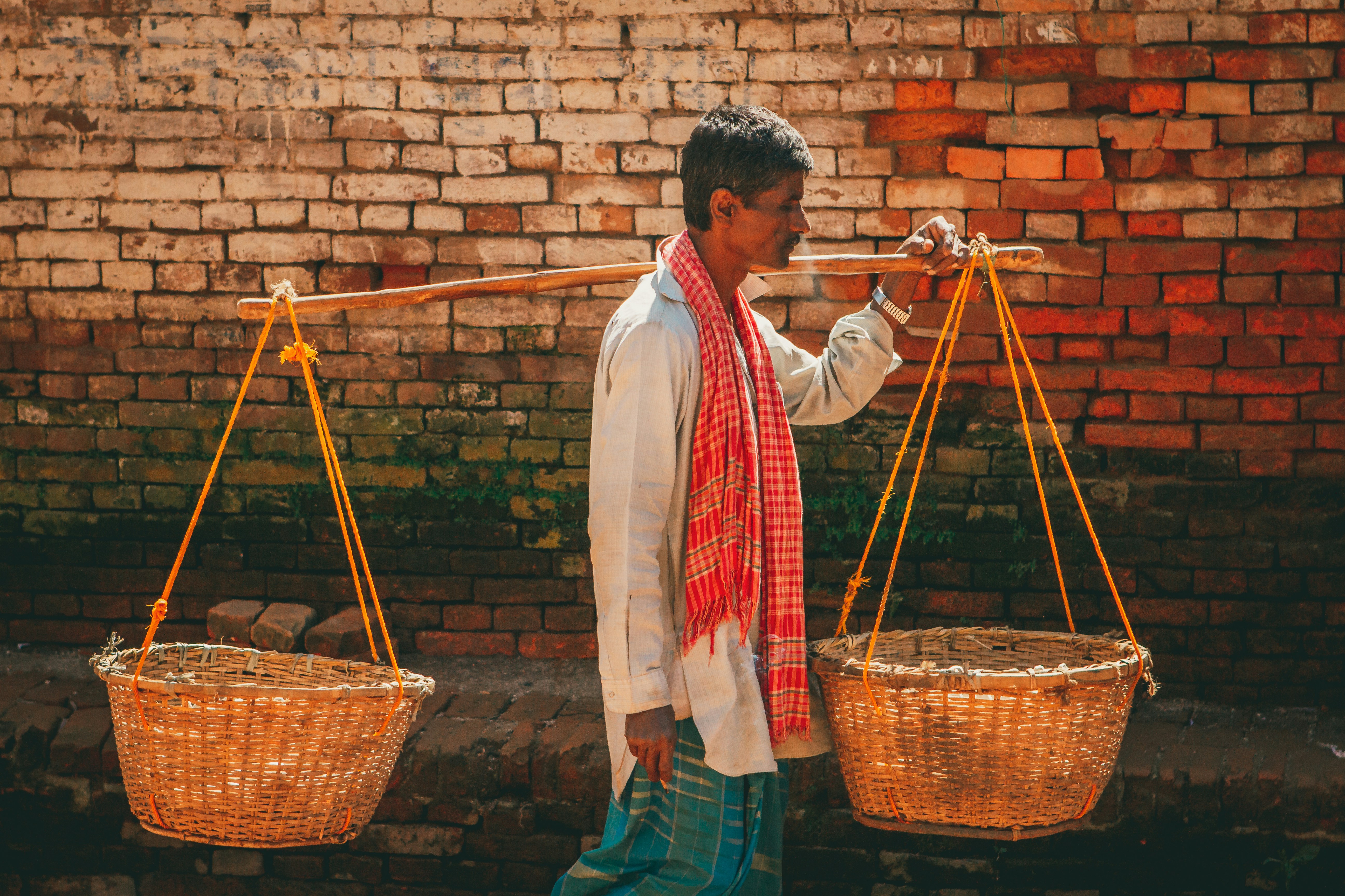A man carrying two baskets on his shoulders photo – Free Bhaktapur ...