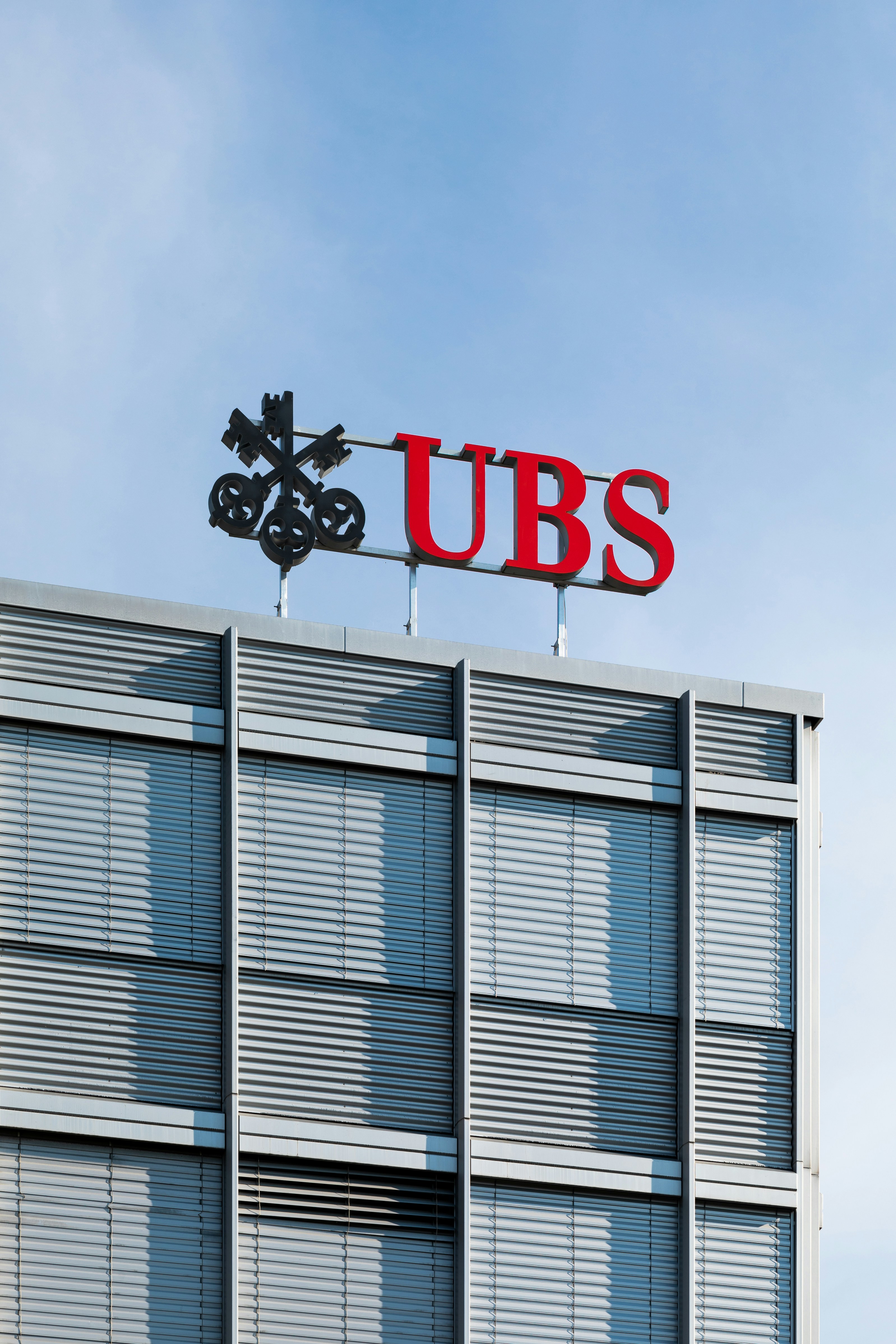 A tall building with a red ubs sign on top of it photo – Free Building ...
