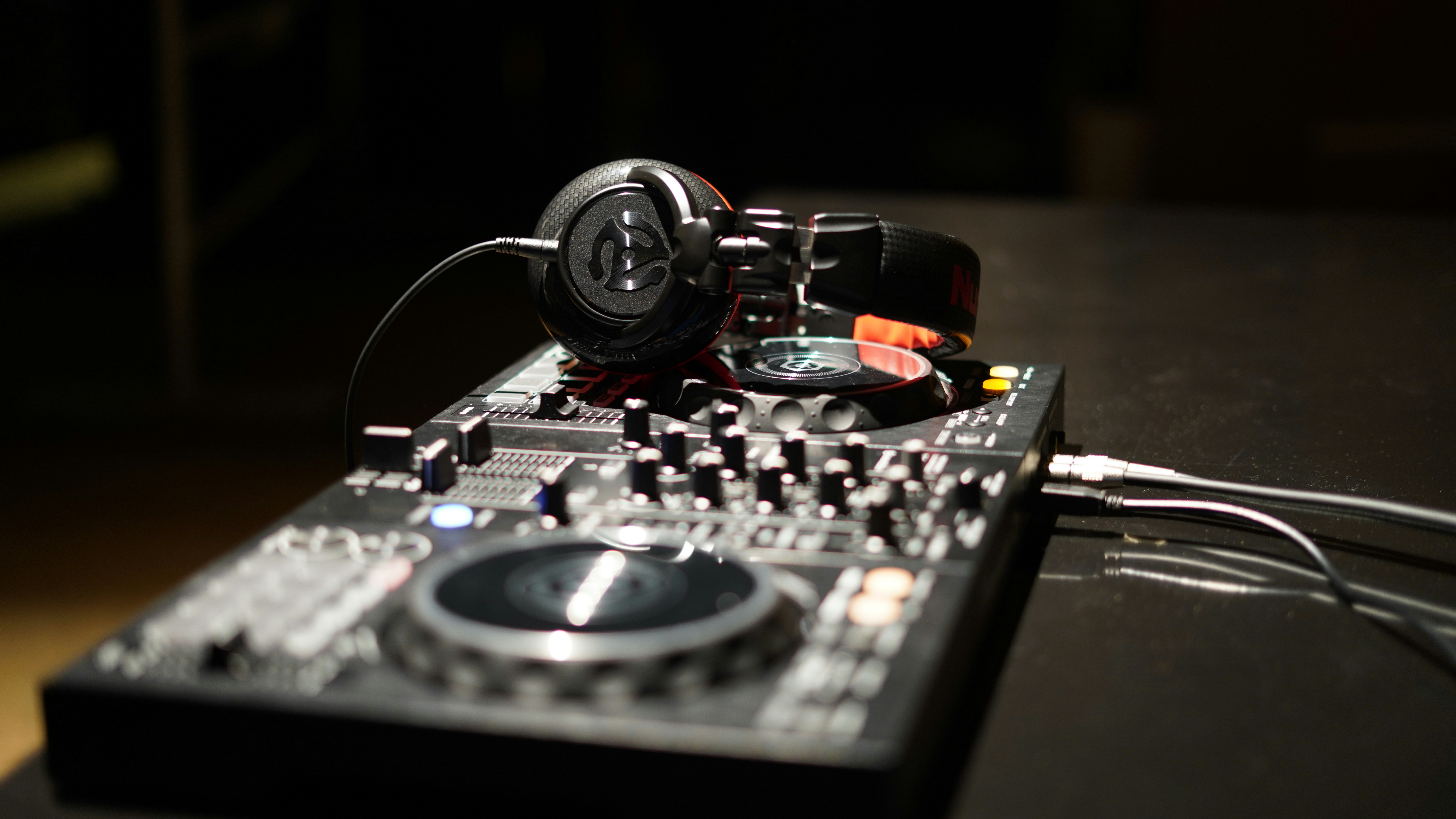 Midnight Groove Rig: Headphones Rest on a DJ Mixer Under a Focused Spotlight