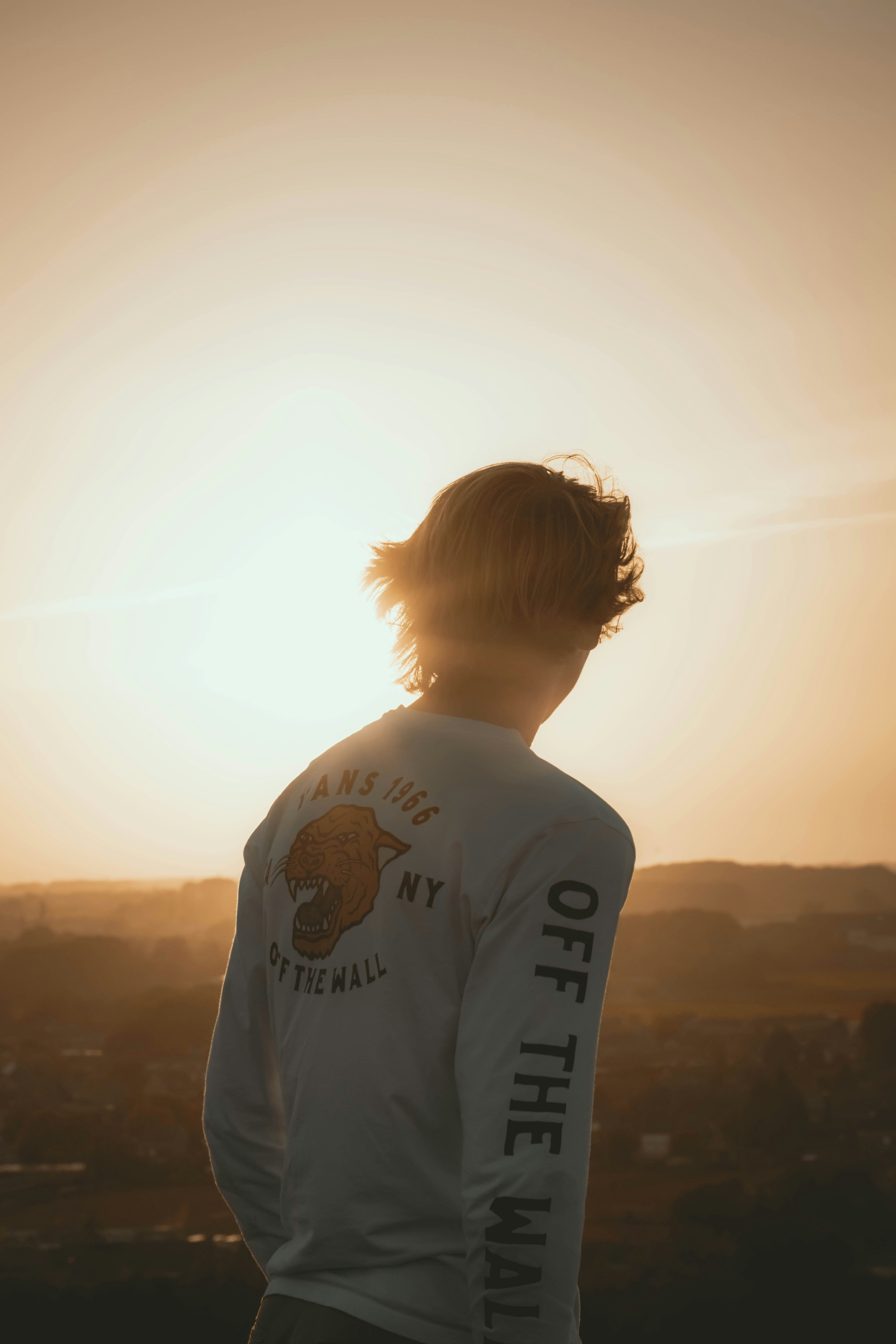 Golden Hour Gaze: Backlit Portrait in a White 'OFF THE WALL' Hoodie