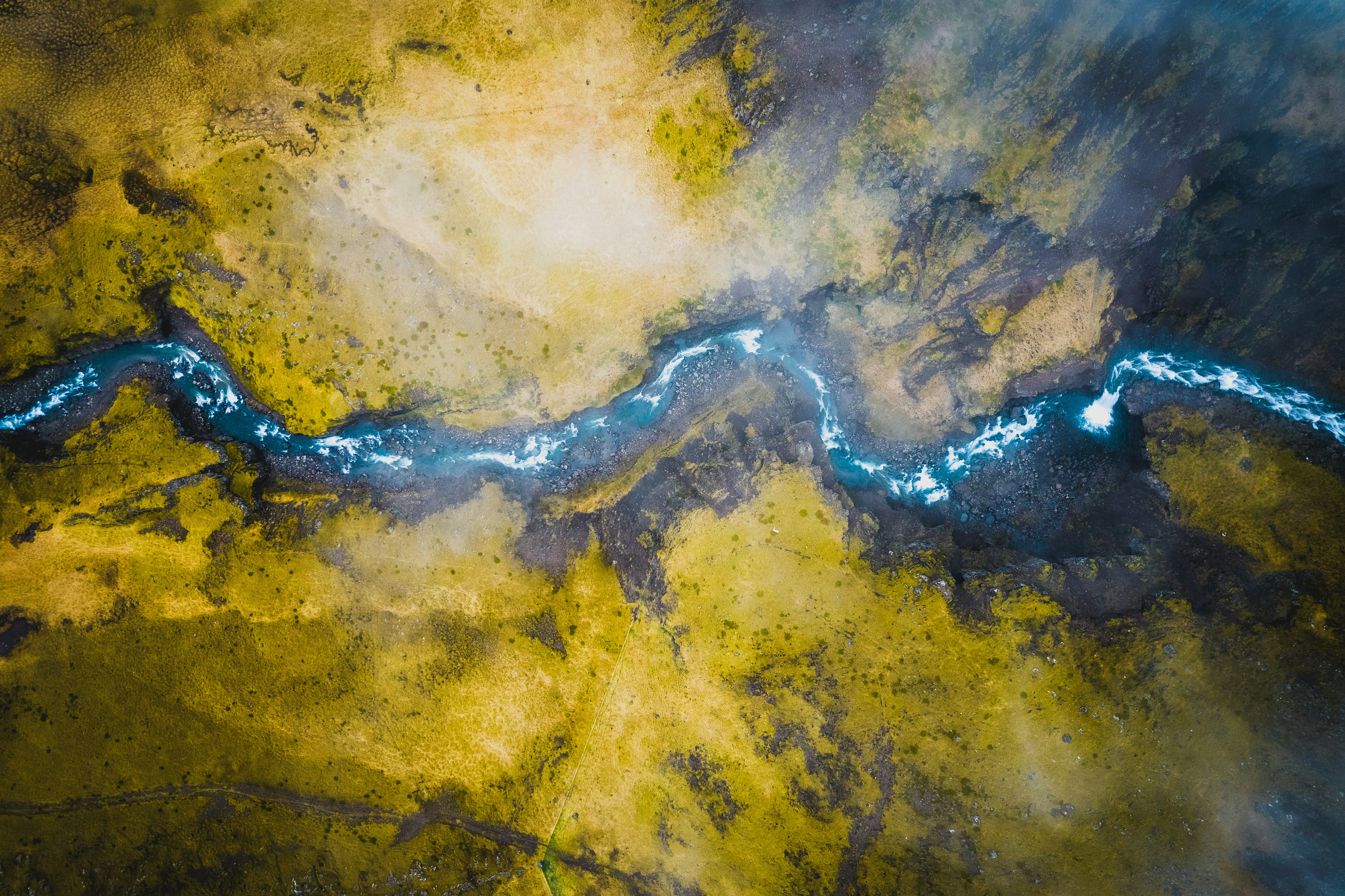 Sinuous river of teal among ochre earth