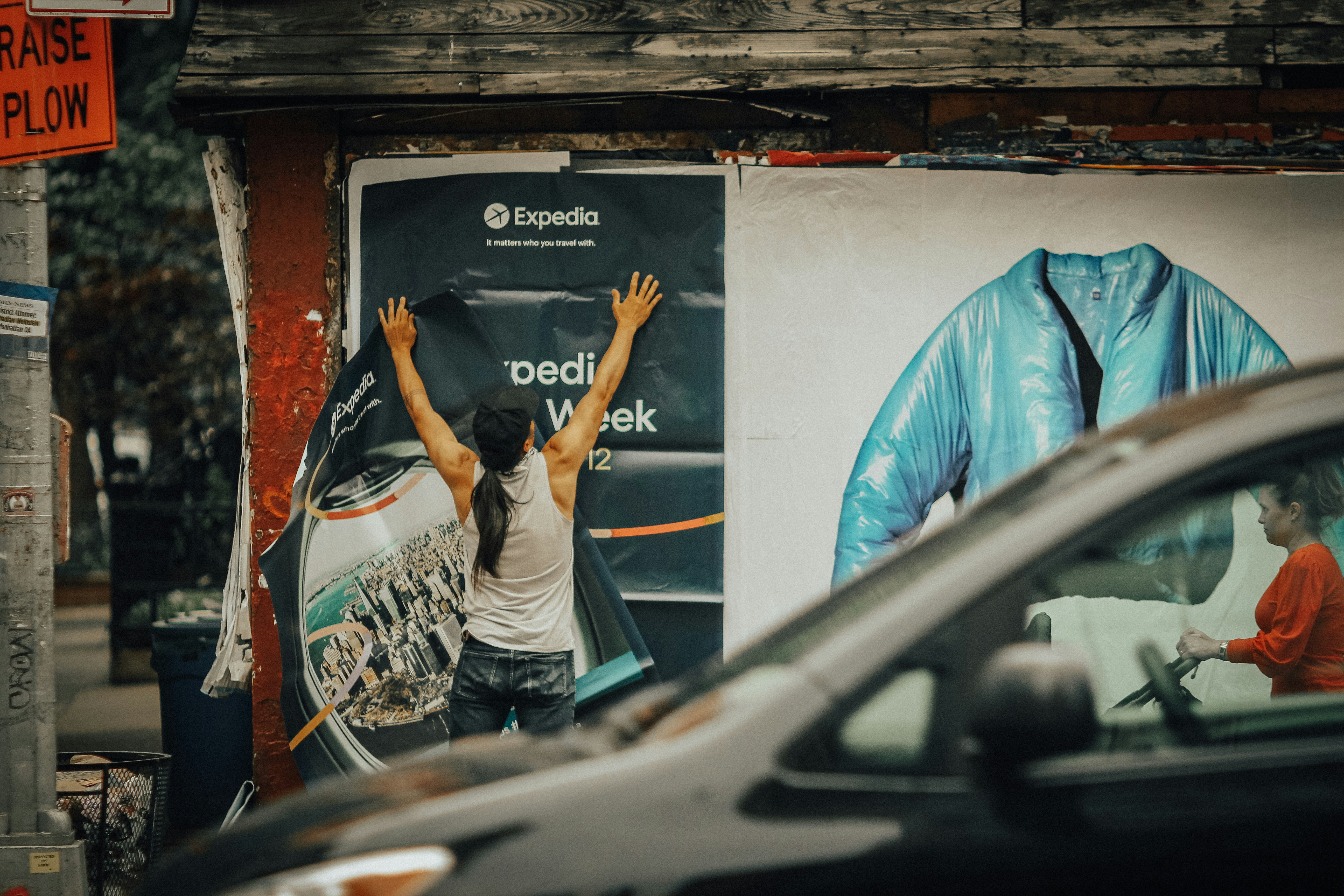 Hands Raised to Meet a Waiting Poster: A Street Scene Unfolds