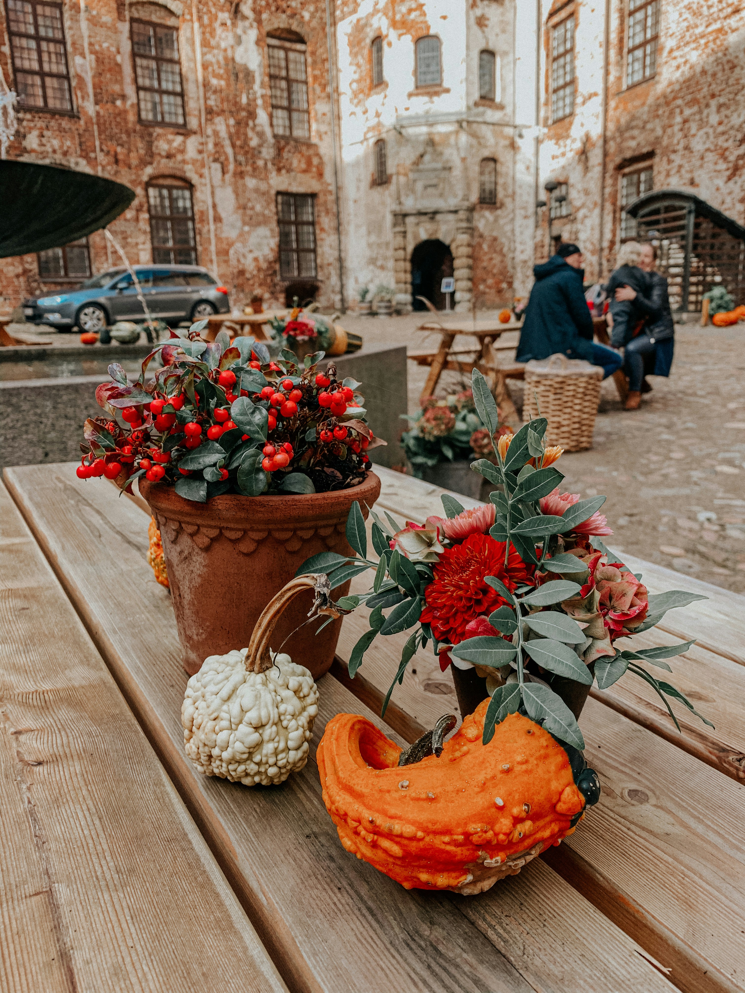 Courtyard Harvest: Pumpkins, Berries, and Floral Still-Life on Weathered Wood