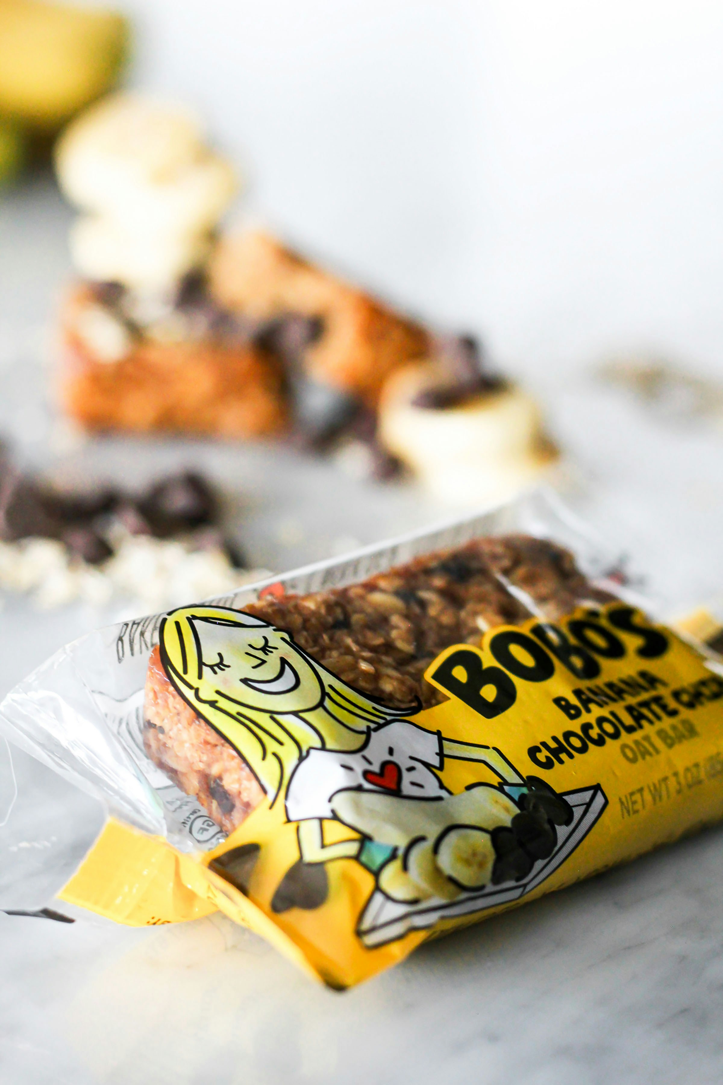 Sunlit Banana-Chocolate Oat Bar in Bold Yellow Wrapper on Marble