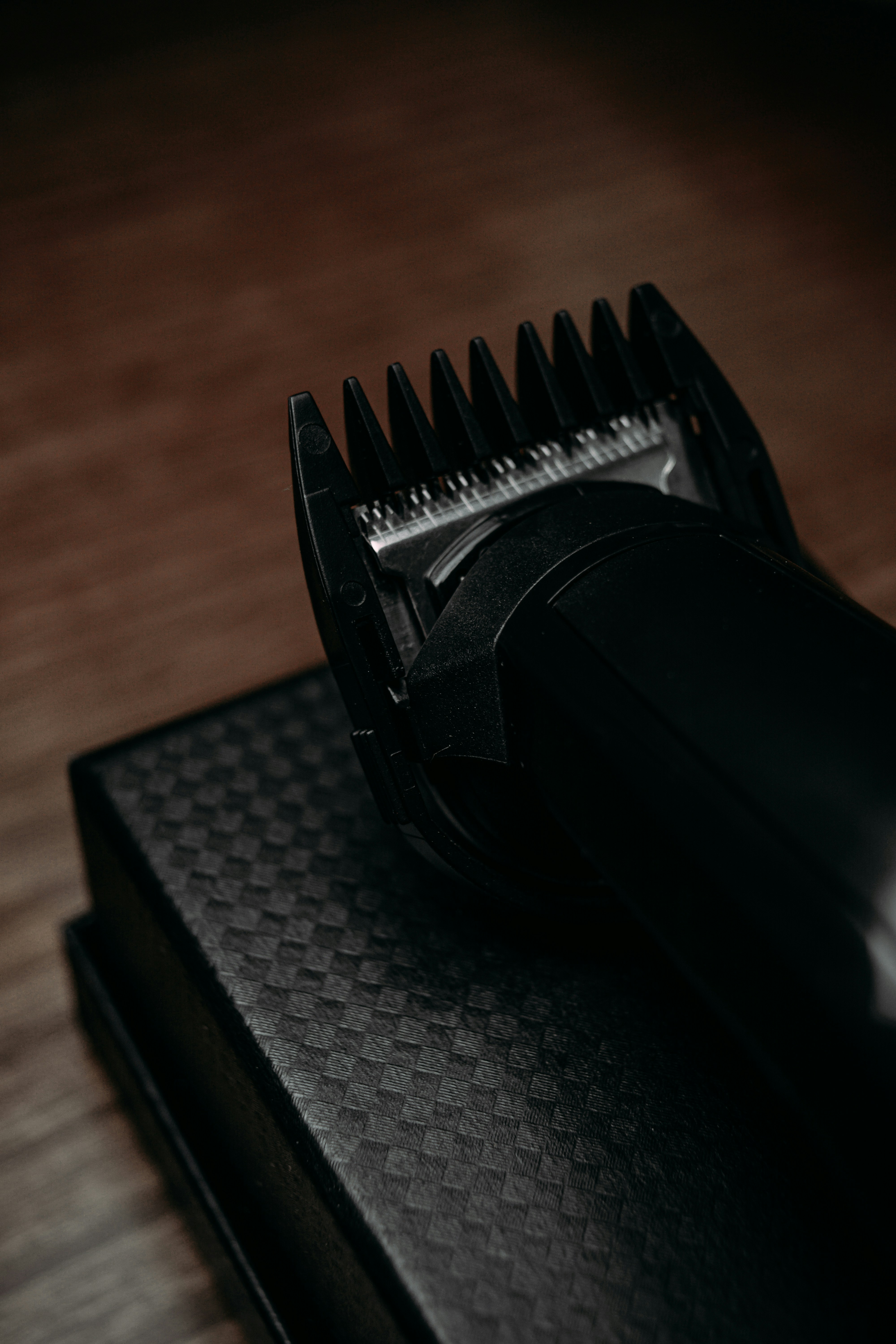 Edge in Focus: Hair Clipper Blade Framed by a Diamond-Texture Mat