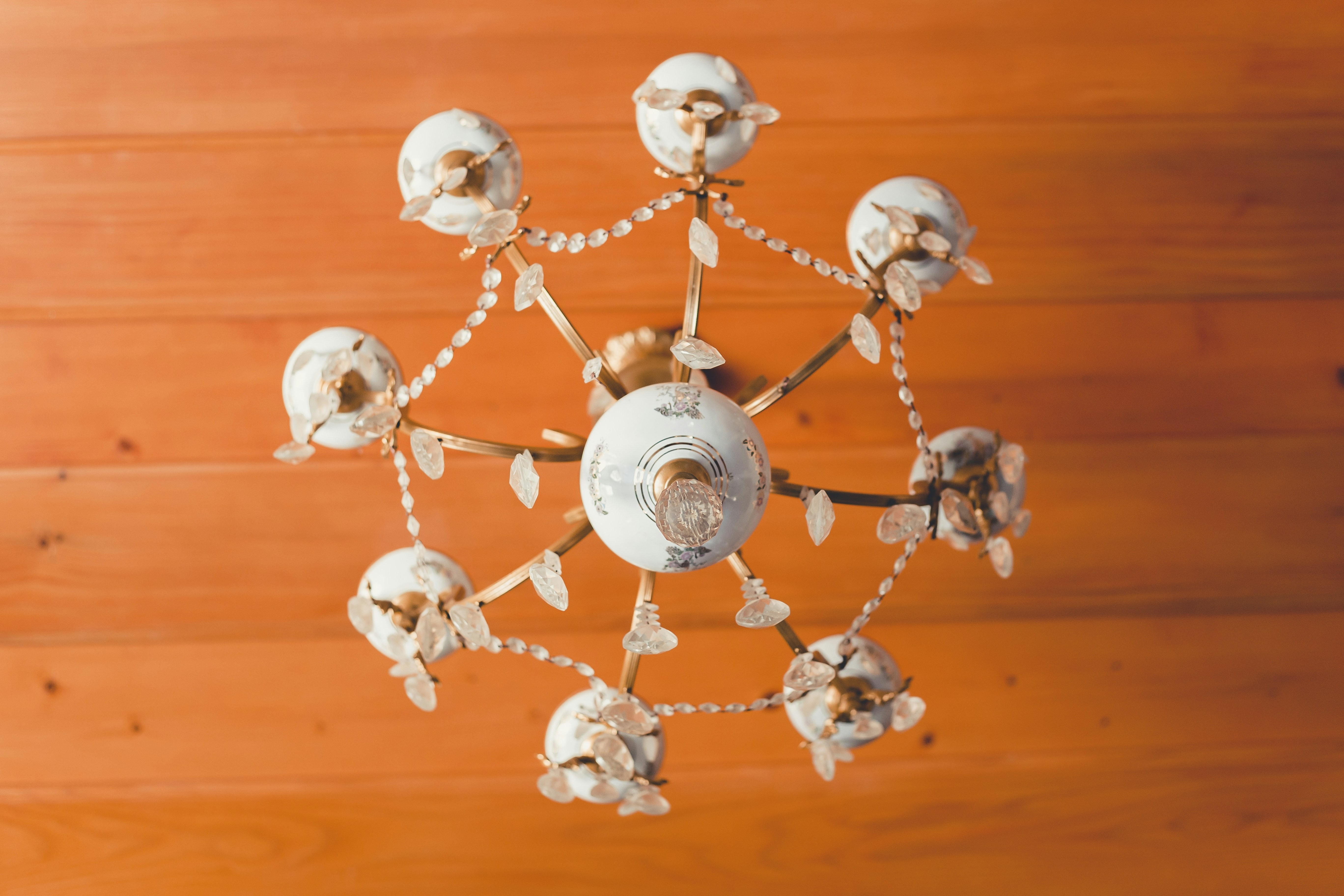 Amber Orbits: A Vintage Chandelier Suspended in Warm Cedar Light