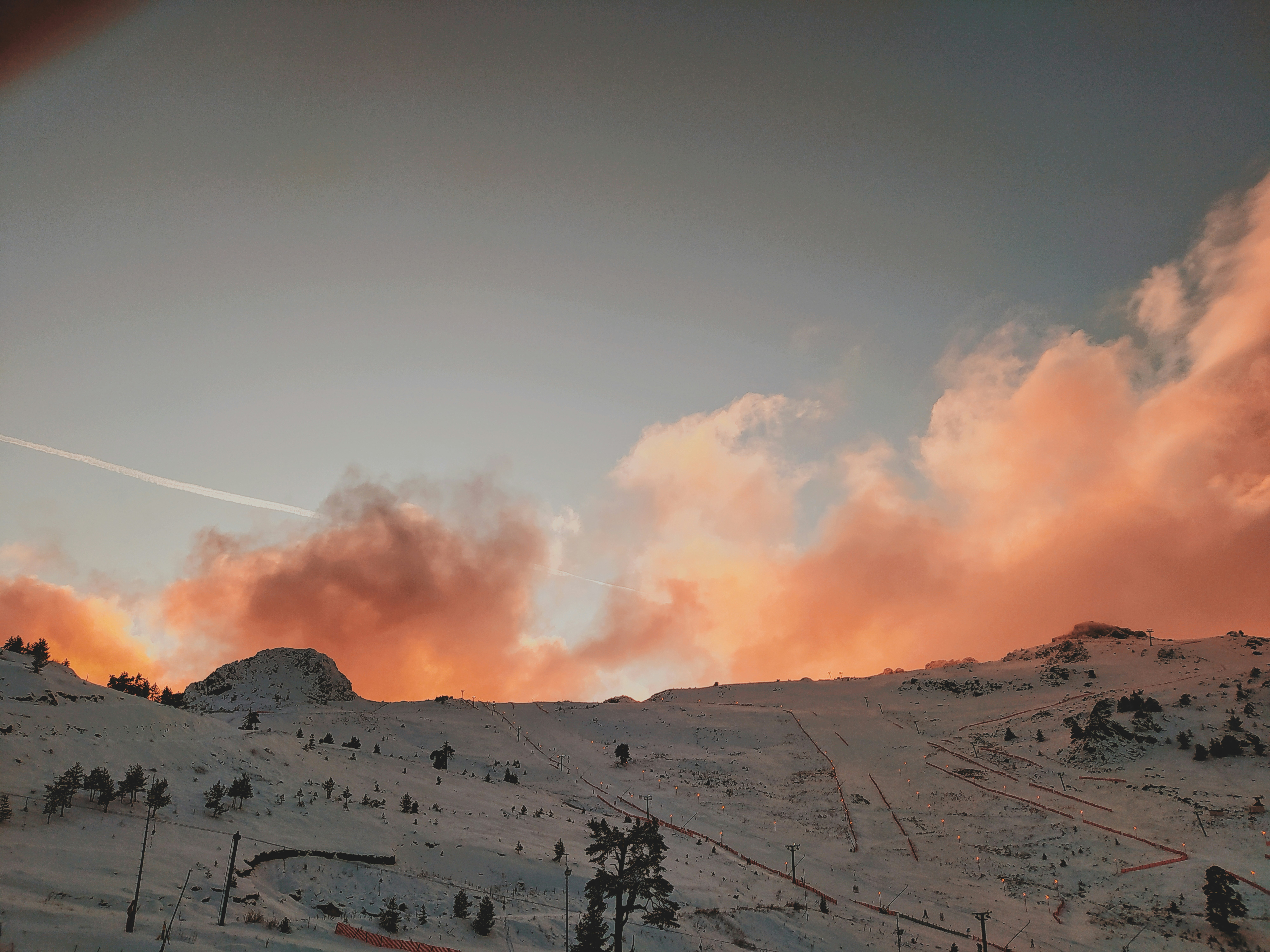 Copper Clouds Over Alpine Snow at Dusk
