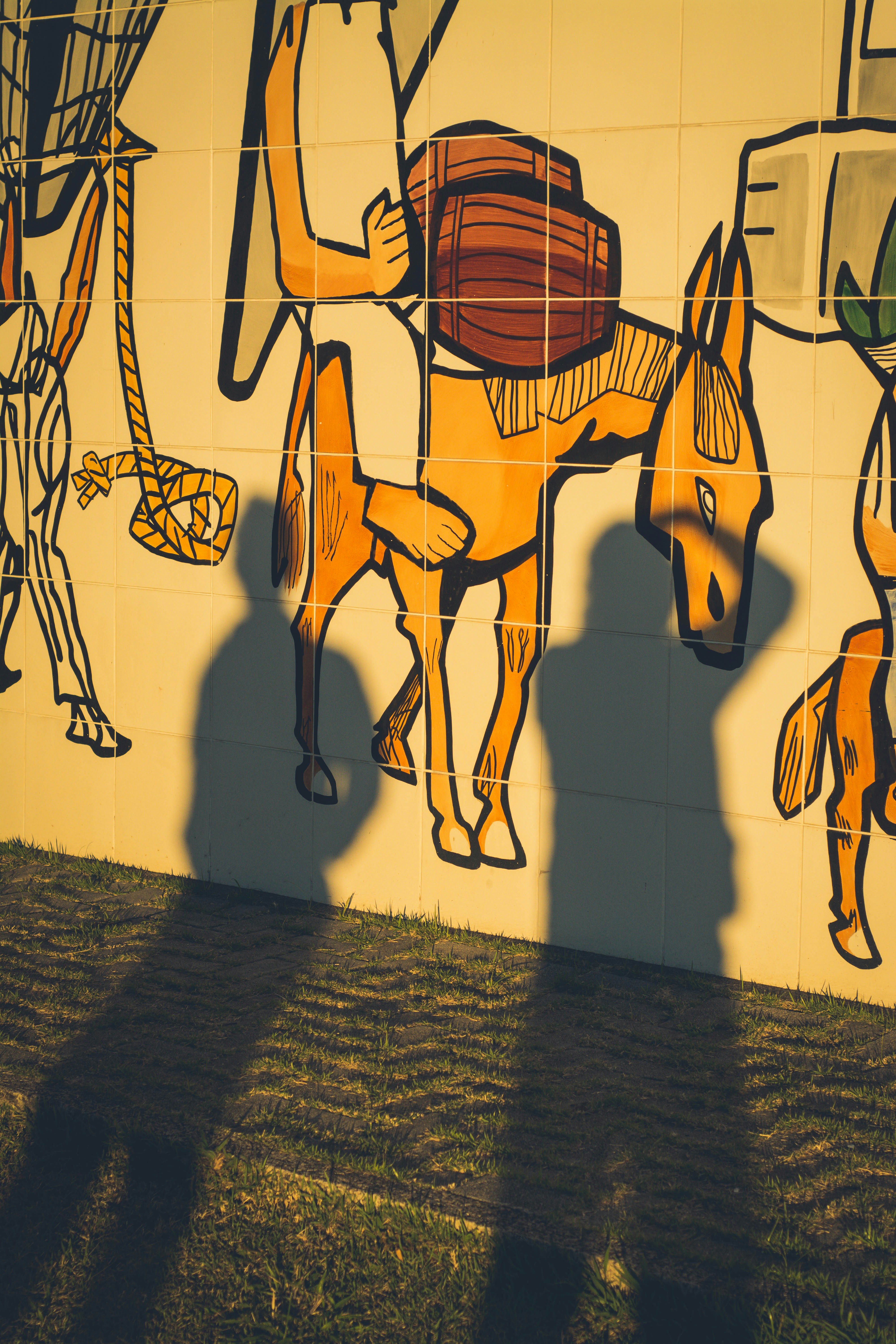 Shadows on a Painted Field: Two Figures Cast Across a Cow-Mk Mural