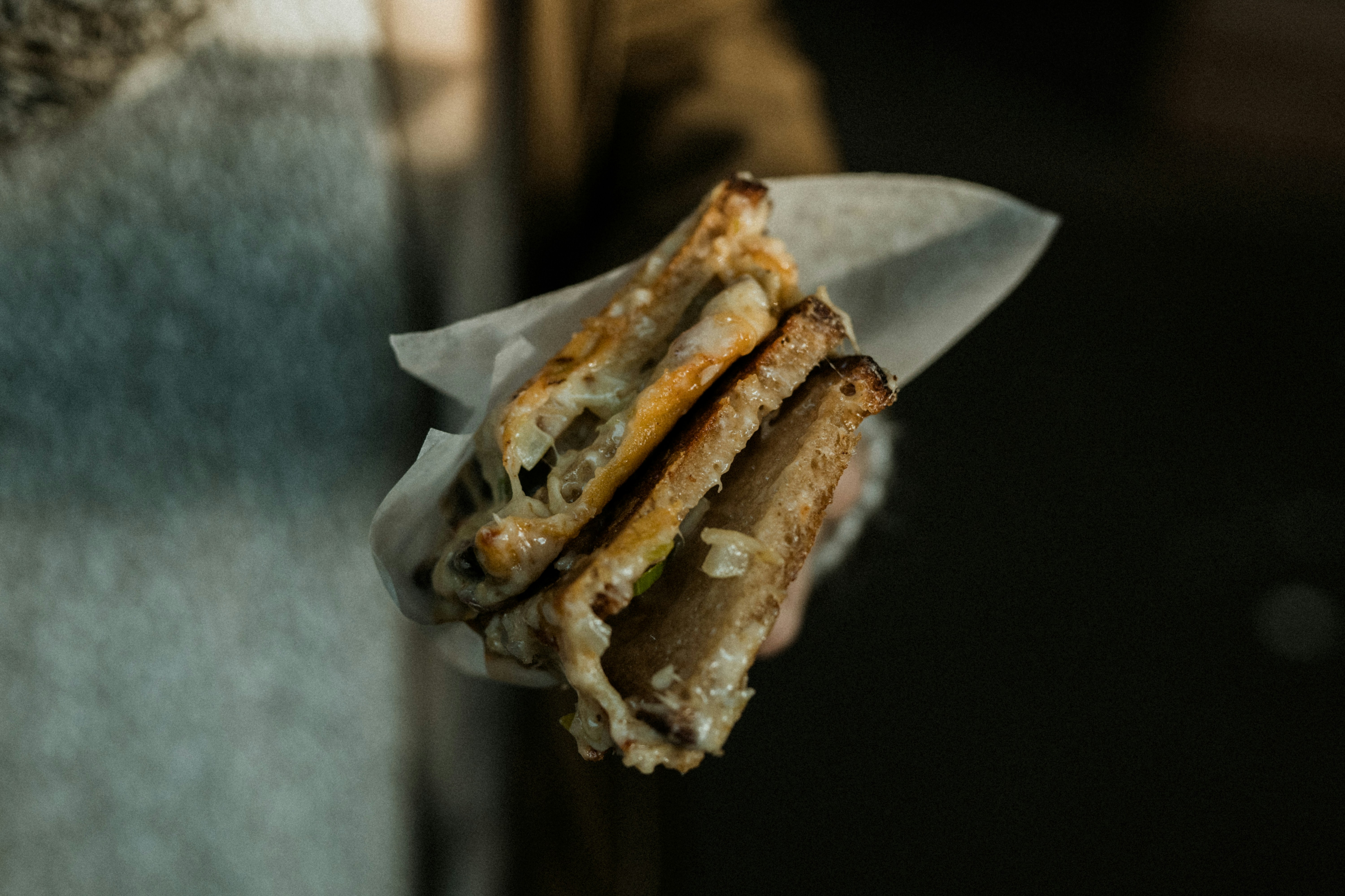 Layered Bite Under Low Light: A Wrapped Meat Stack