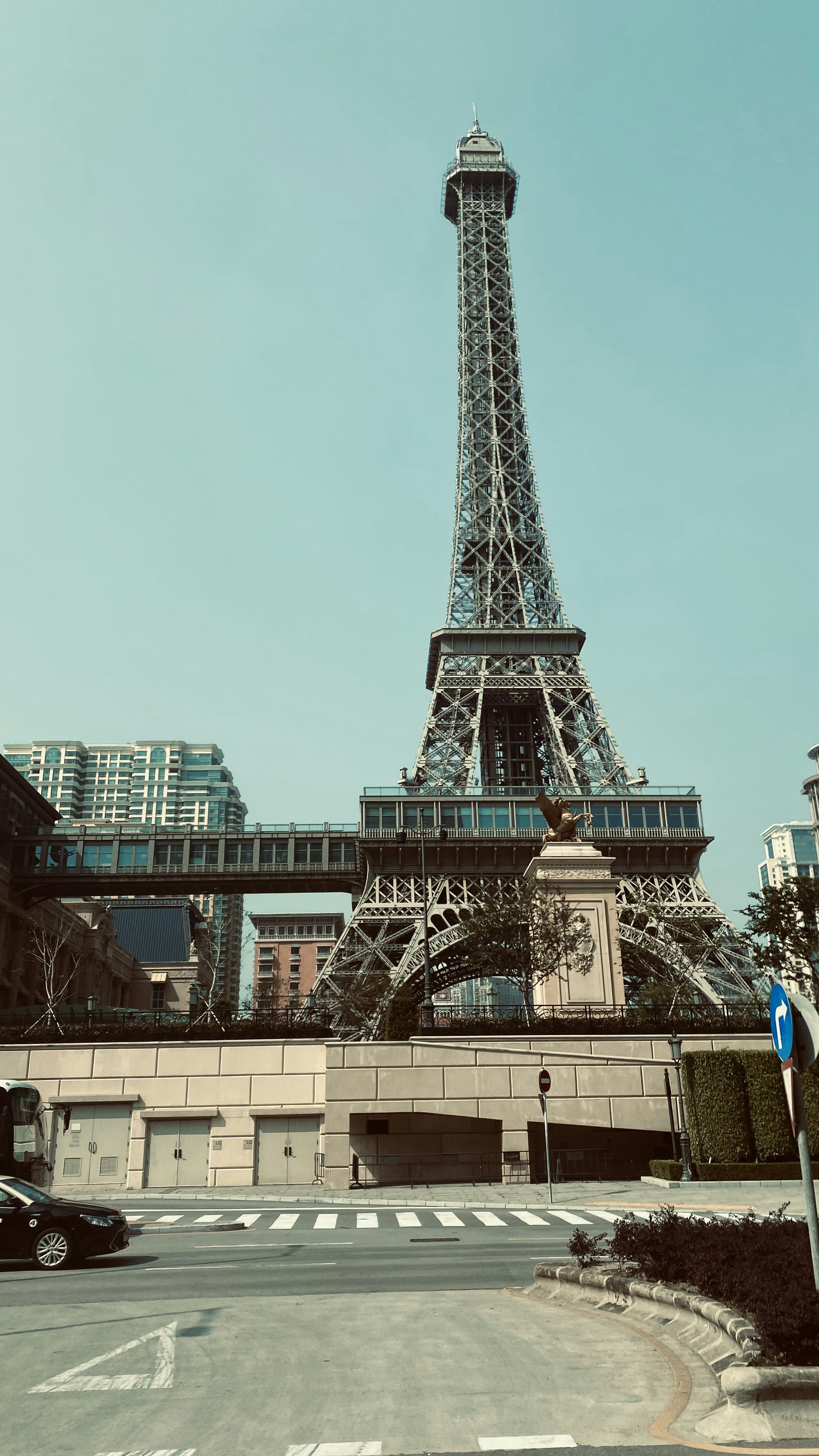 The Eiffel Tower replica stands tall amidst modern buildings, showcasing a blend of classic and contemporary design elements.