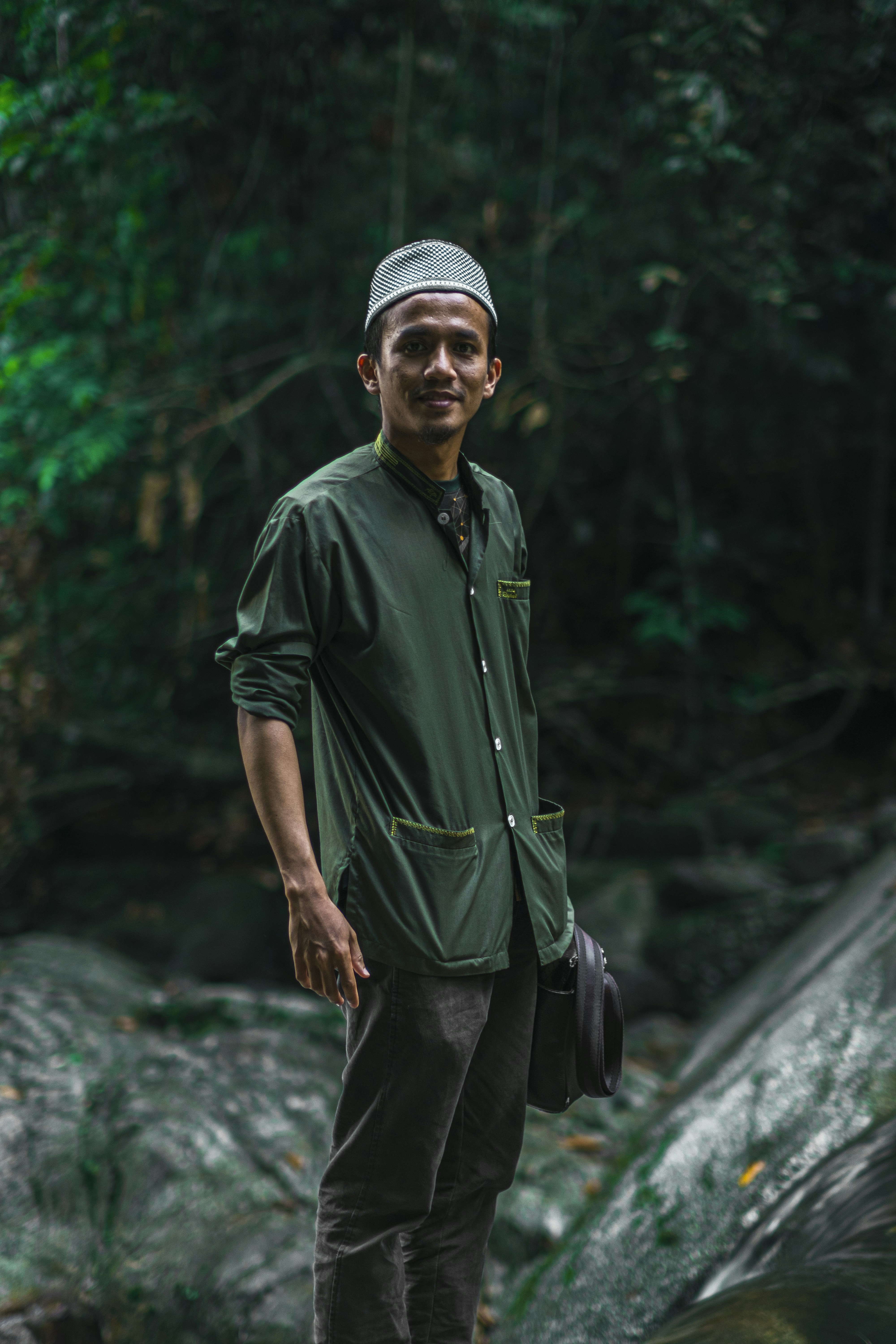 Green-robed traveler by a forest stream at dusk
