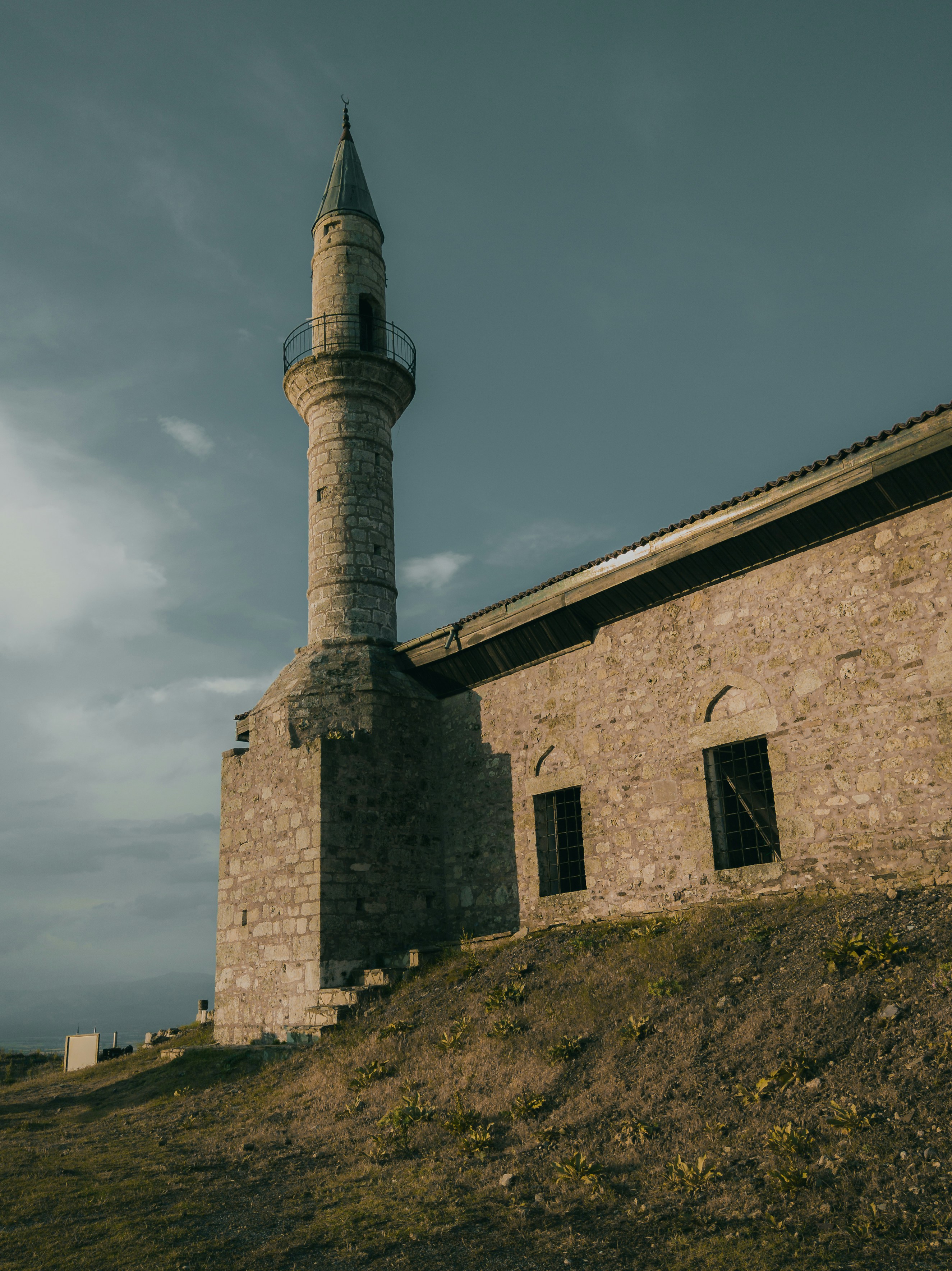 Historic stone tower rising against a moody sky, showcasing intricate architectural details and a weathered facade.
