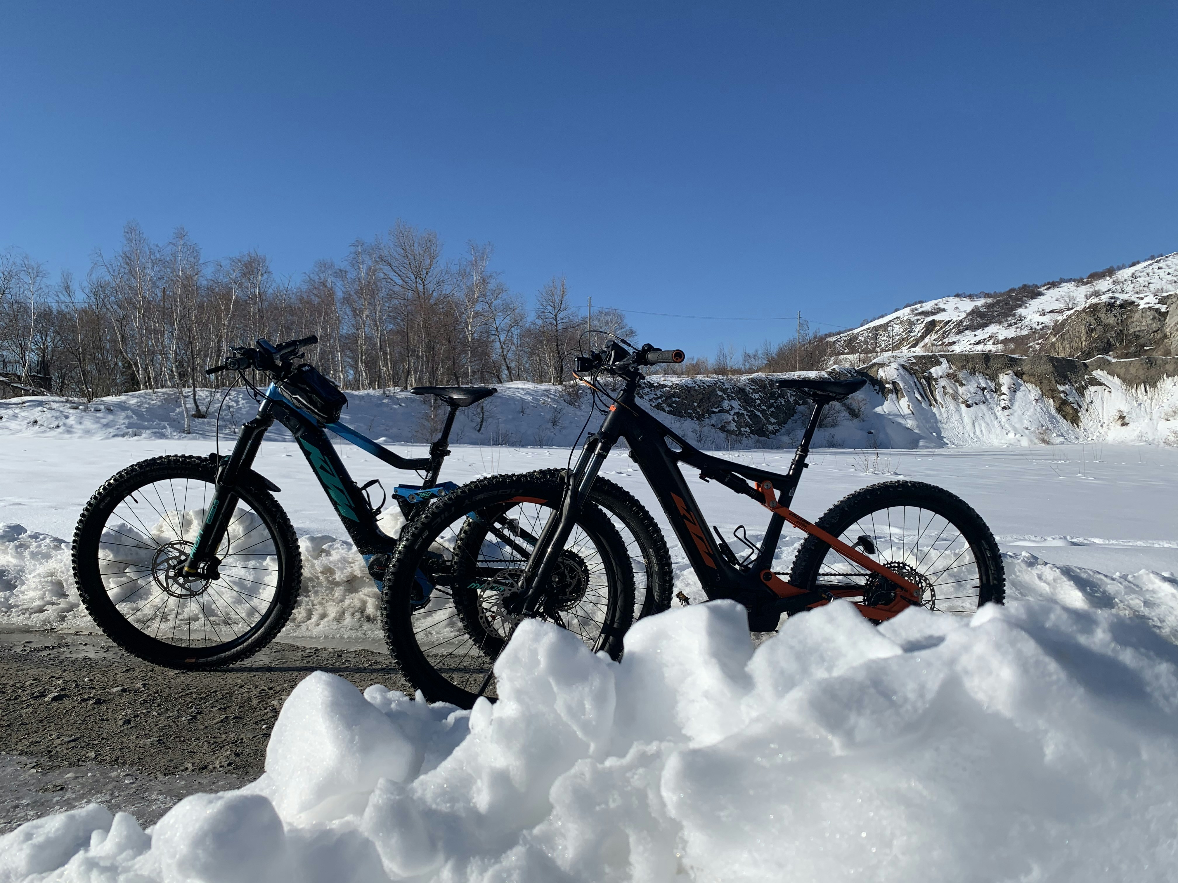 Twin Mountain Bikes Quietly Anchored in Fresh Snow Under a Clear Alpine Sky