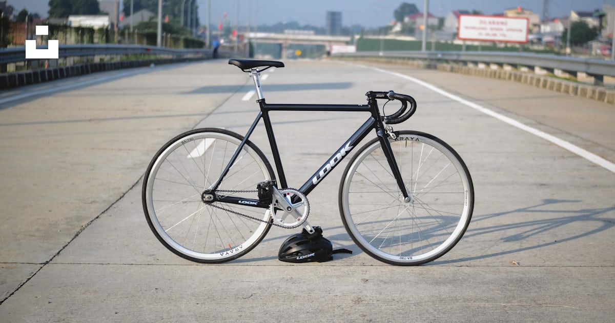 昼間の灰色のコンクリート道路を走る黒と灰色のロードバイクの写真 Unsplashの自転車の無料画像