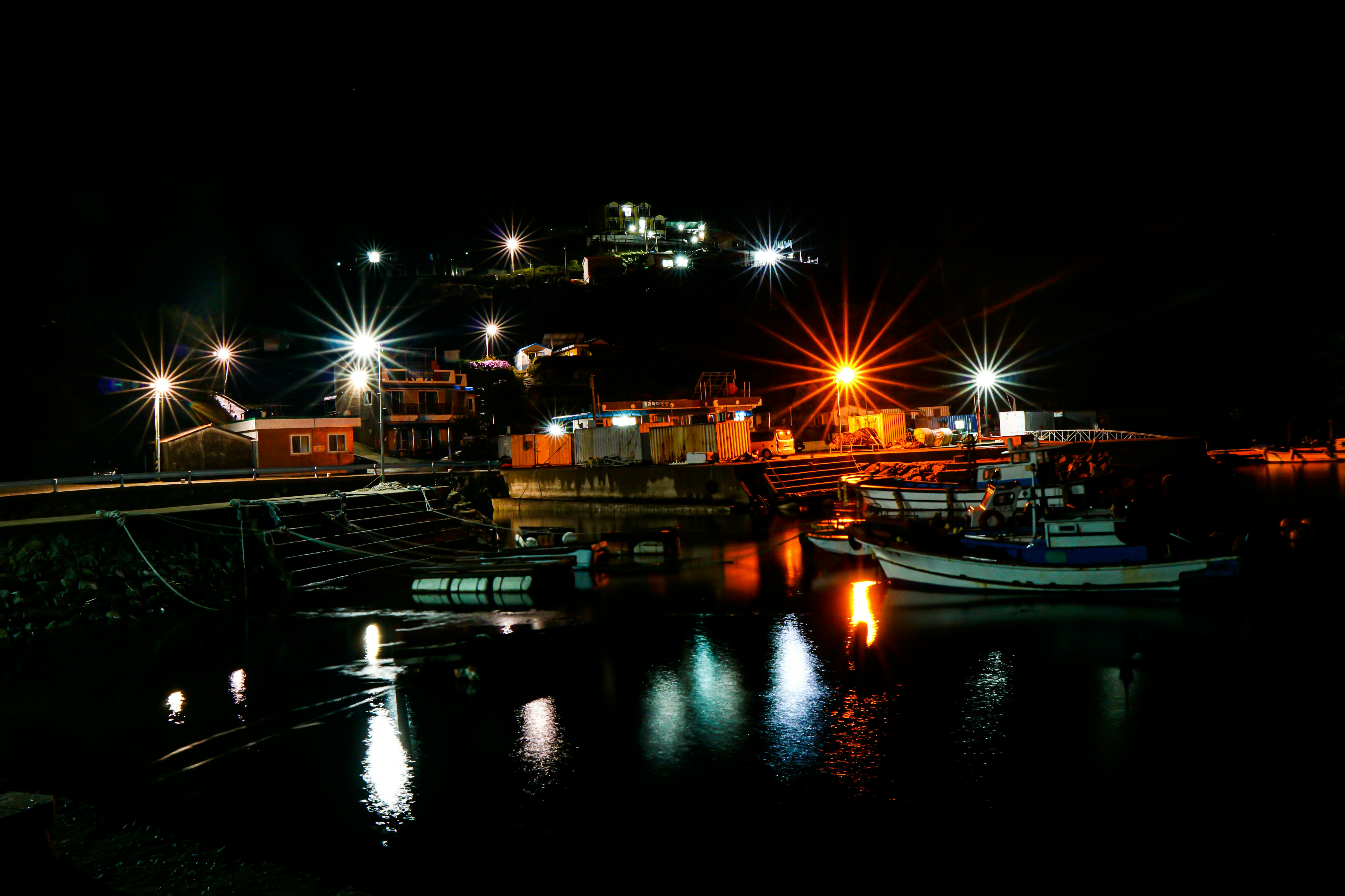 boat on water near dock during night time