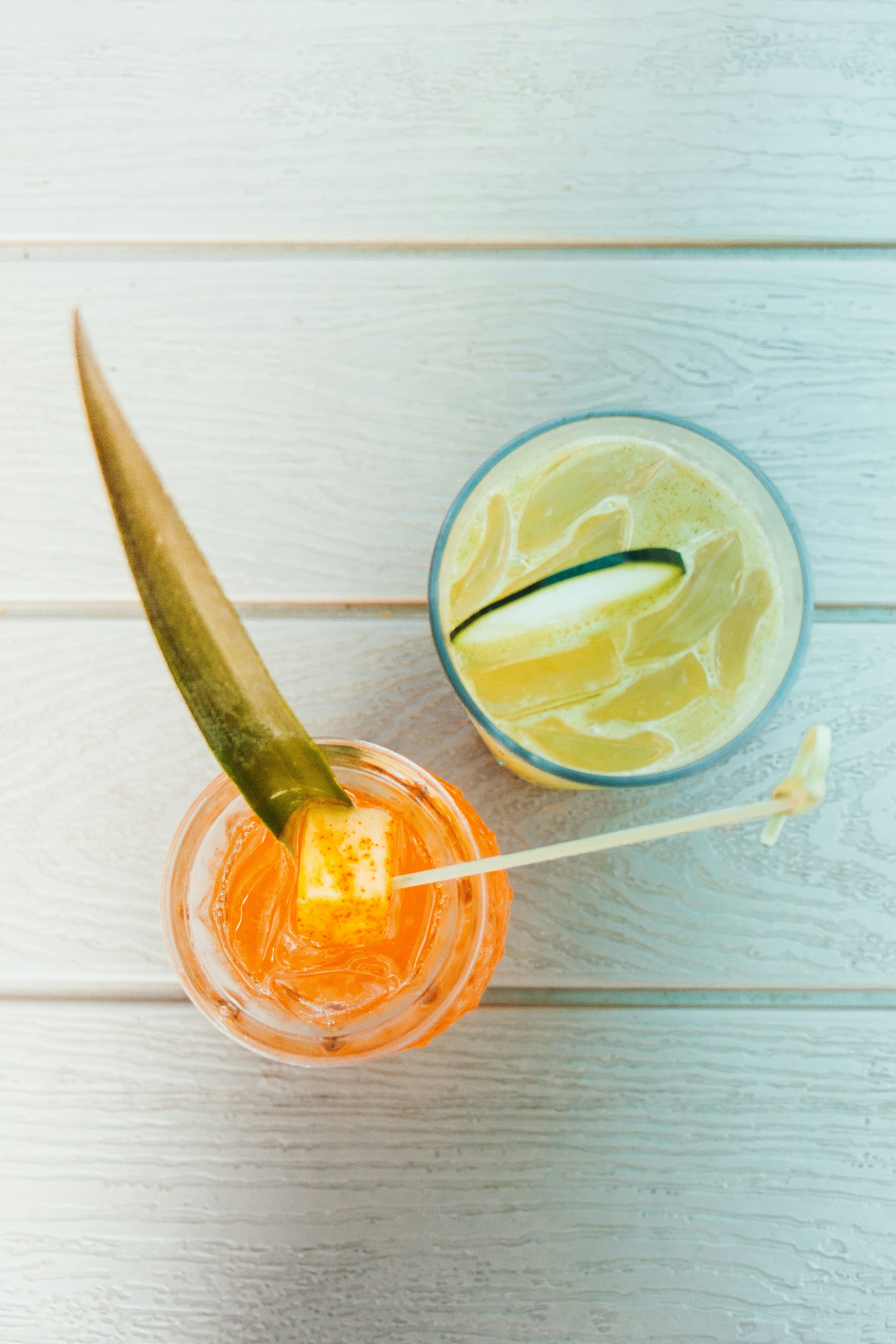 Orange Oasis and Lime Lullaby: Tropical Cocktails on Weathered Blue Wood