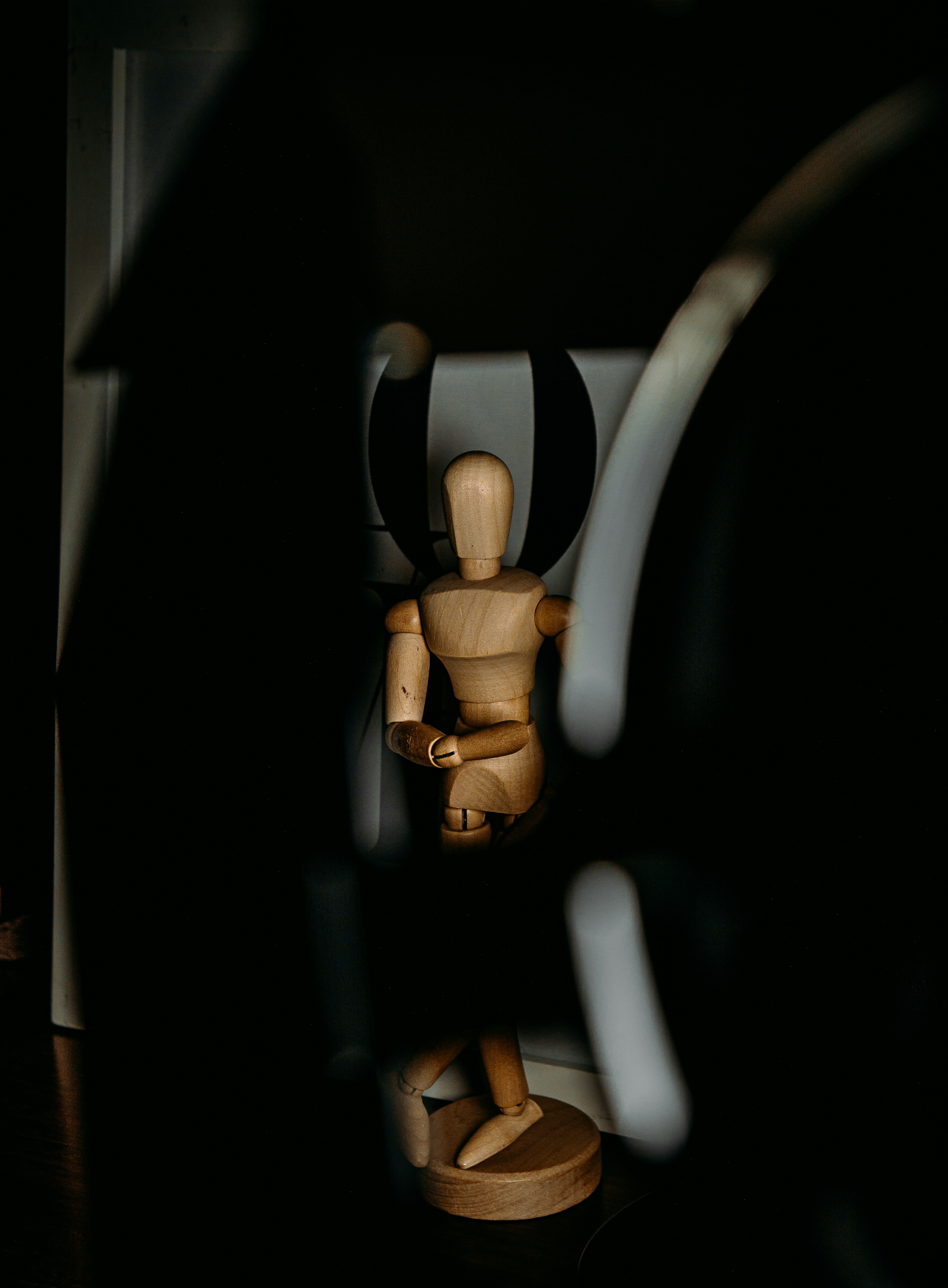 Wooden Figure in a Dim Studio: A Quiet Desk Scene
