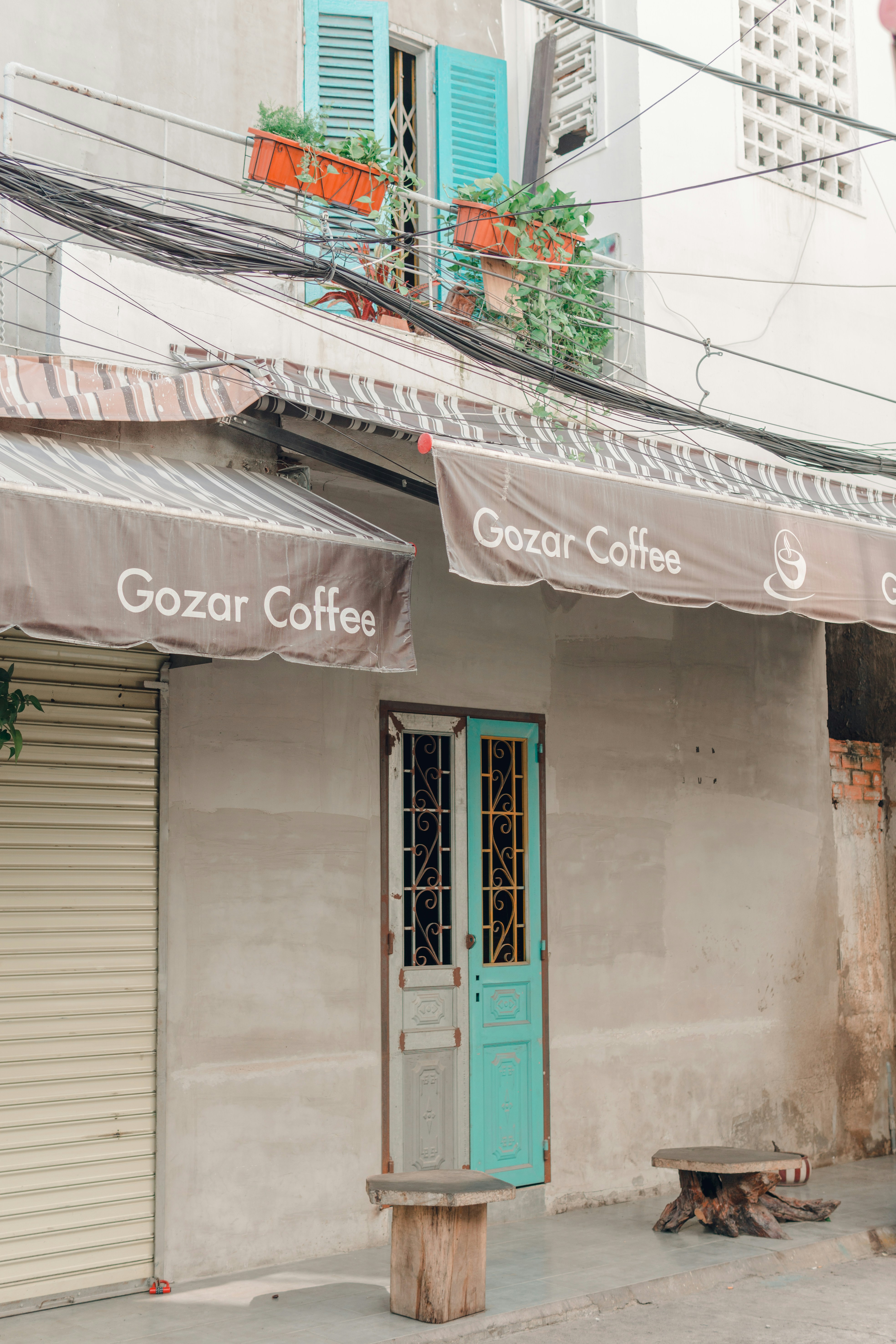 Turquoise Doorway Under Weathered Awnings: A Quiet Streetfront Coffee Nook
