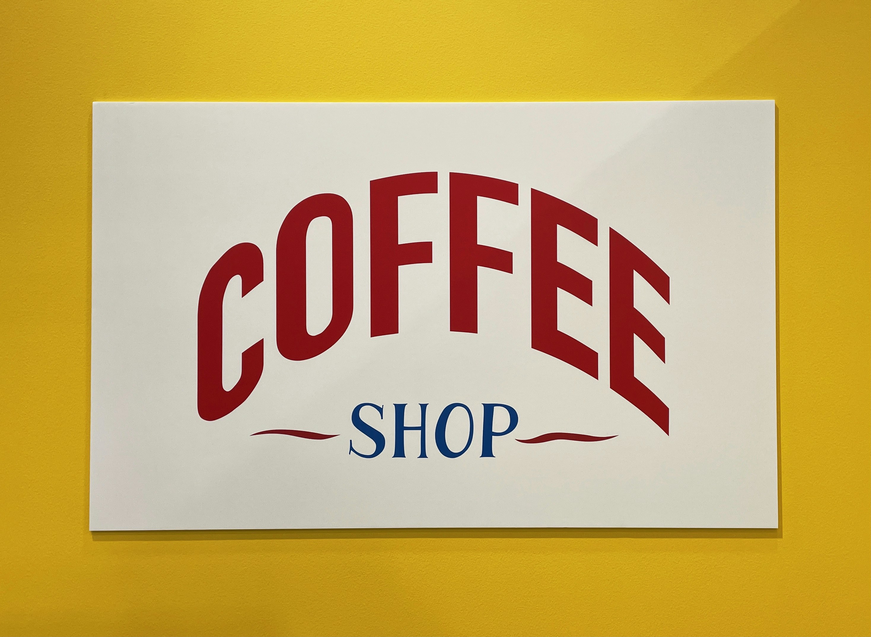 A coffee shop sign on a yellow wall photo – Free Art Image on Unsplash
