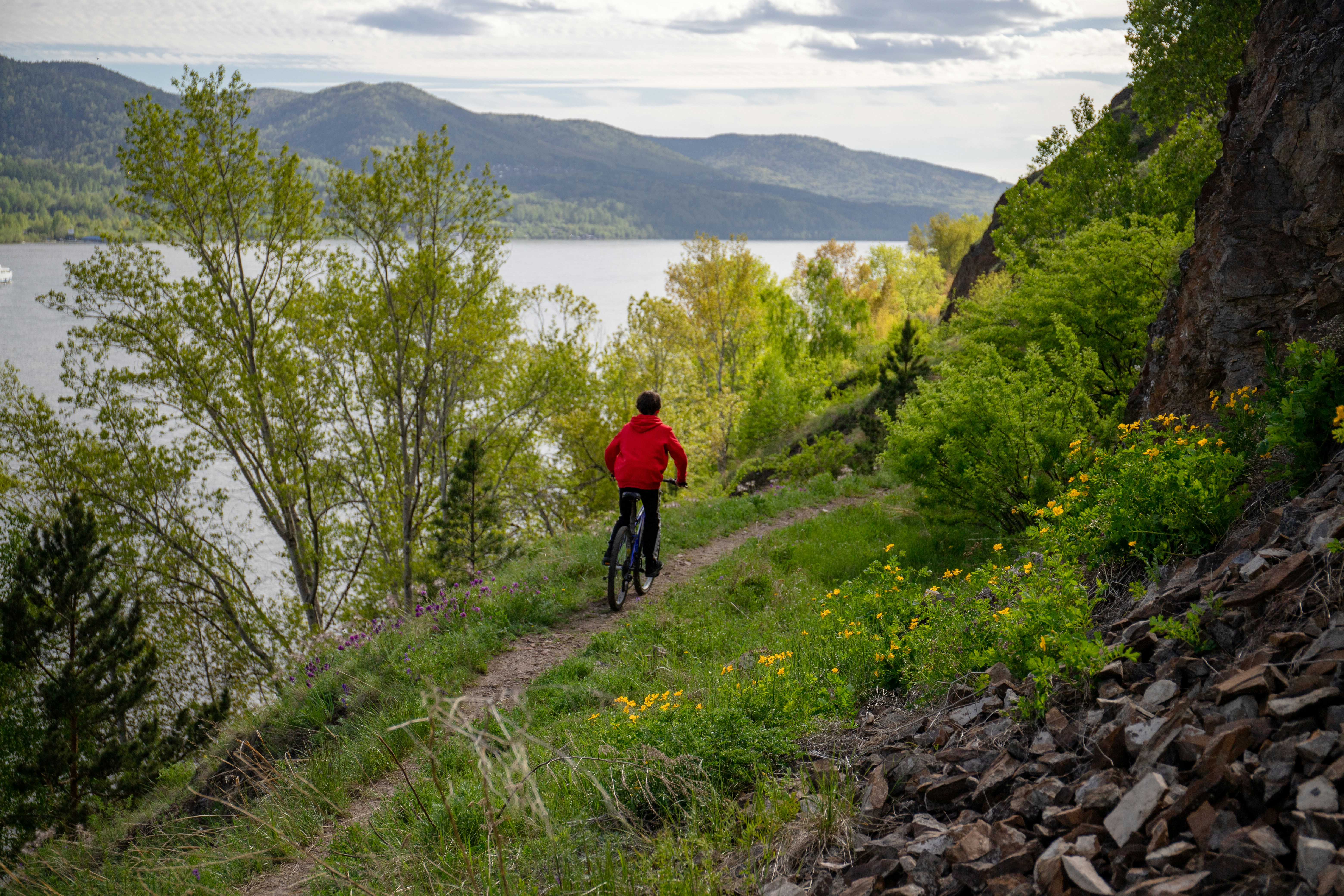 Cliffside Trail Rider: A Red-Jacketed Explorer Conquers the Sloped Path