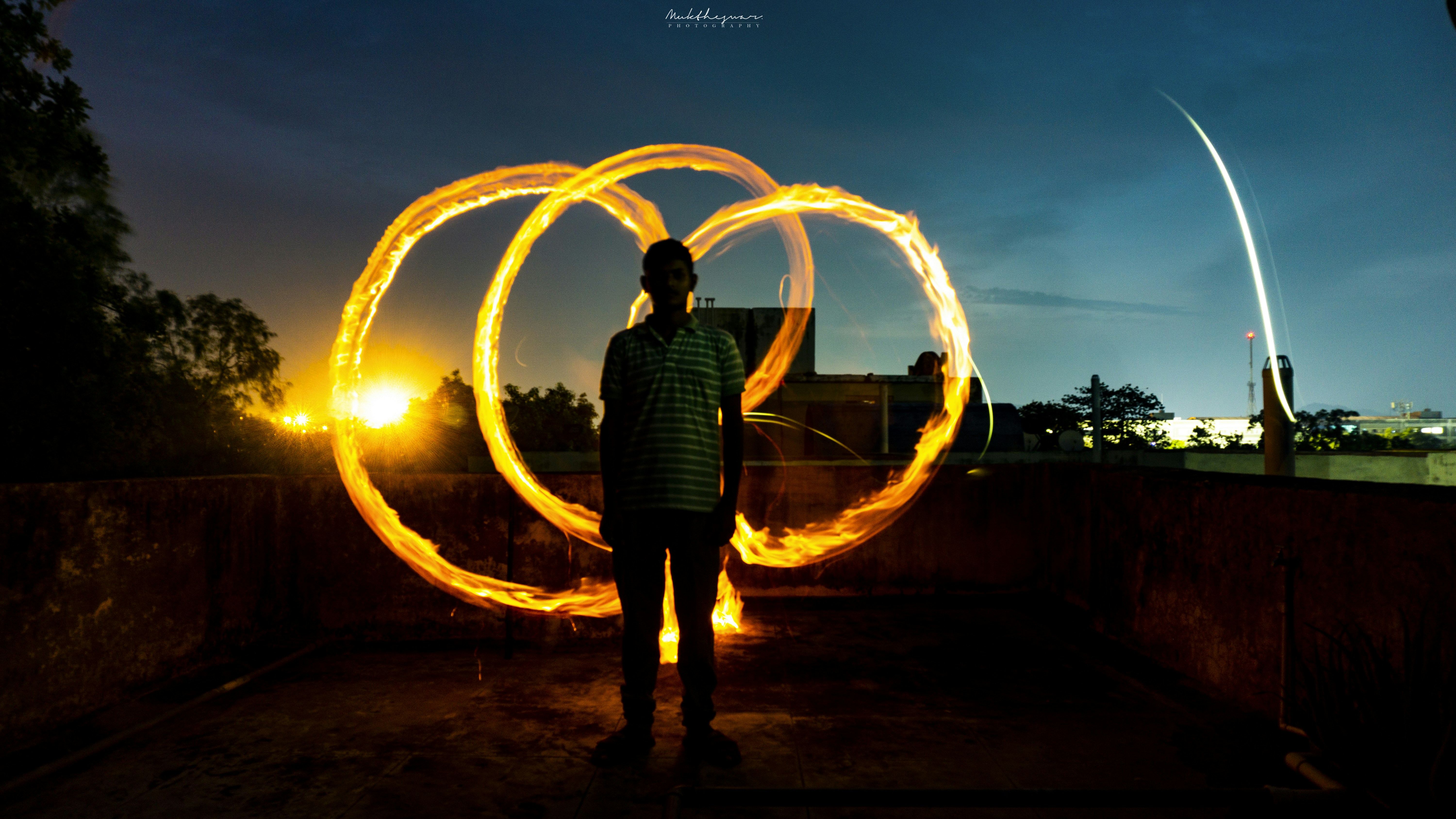 Portrait in Firelight: A Silhouette Between Ringed Trails