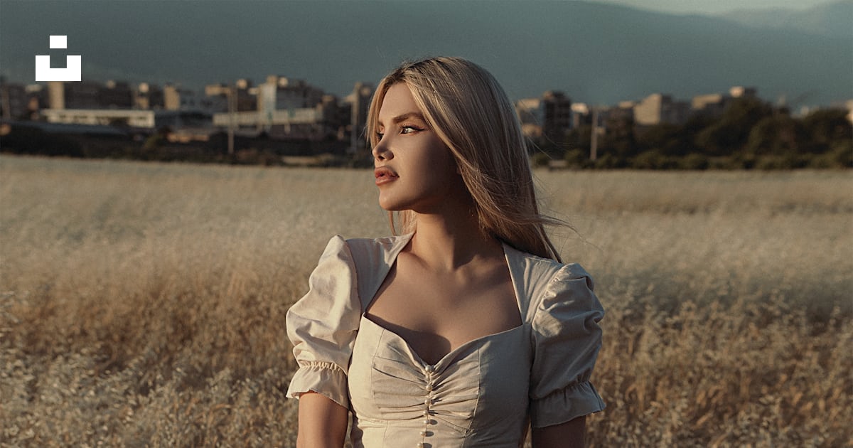 昼間、茶色の草原に座る白いドレスを着た女性の写真 Unsplashのファッションモデルの無料画像