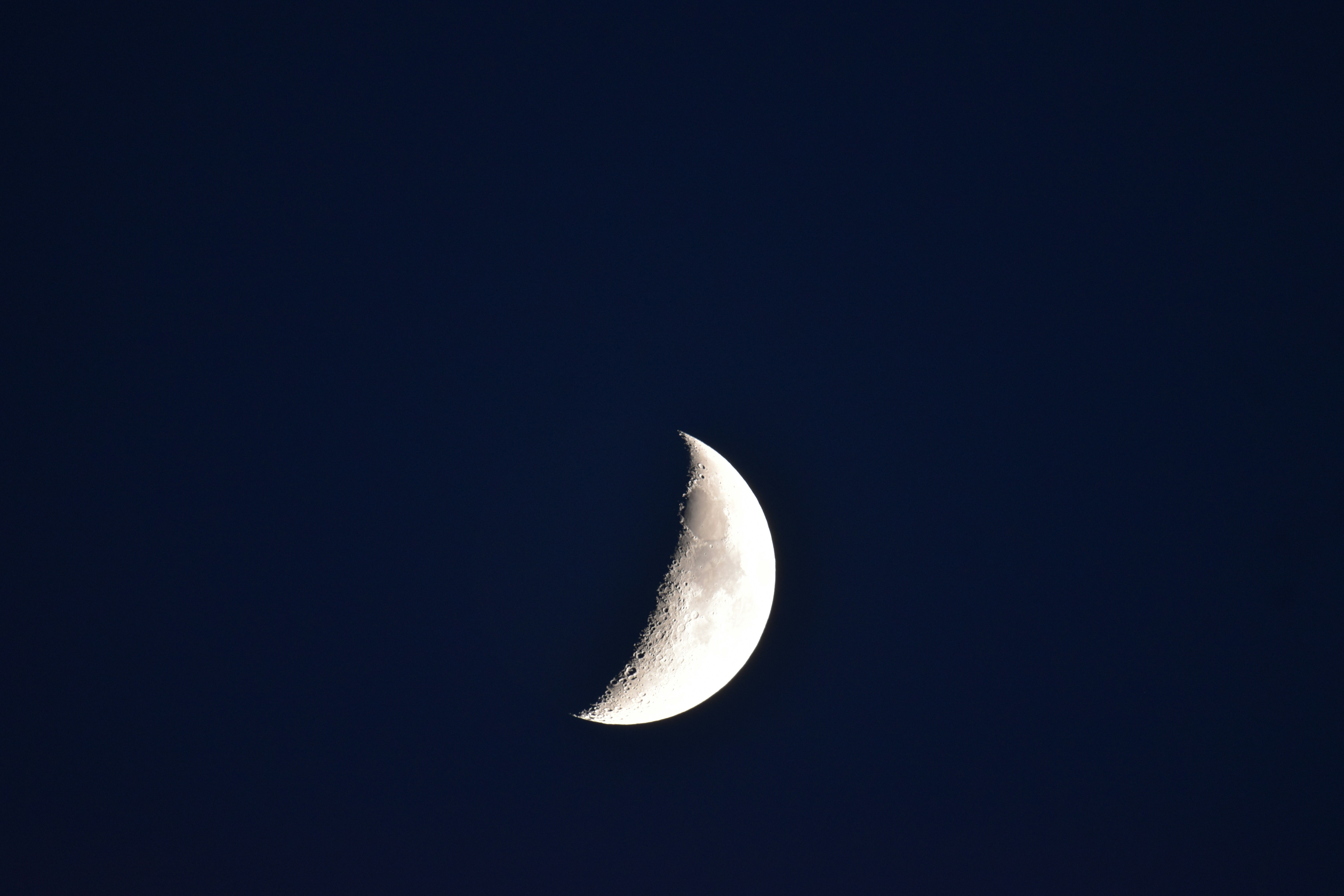 Crescent moon shining brightly in a dark night sky.