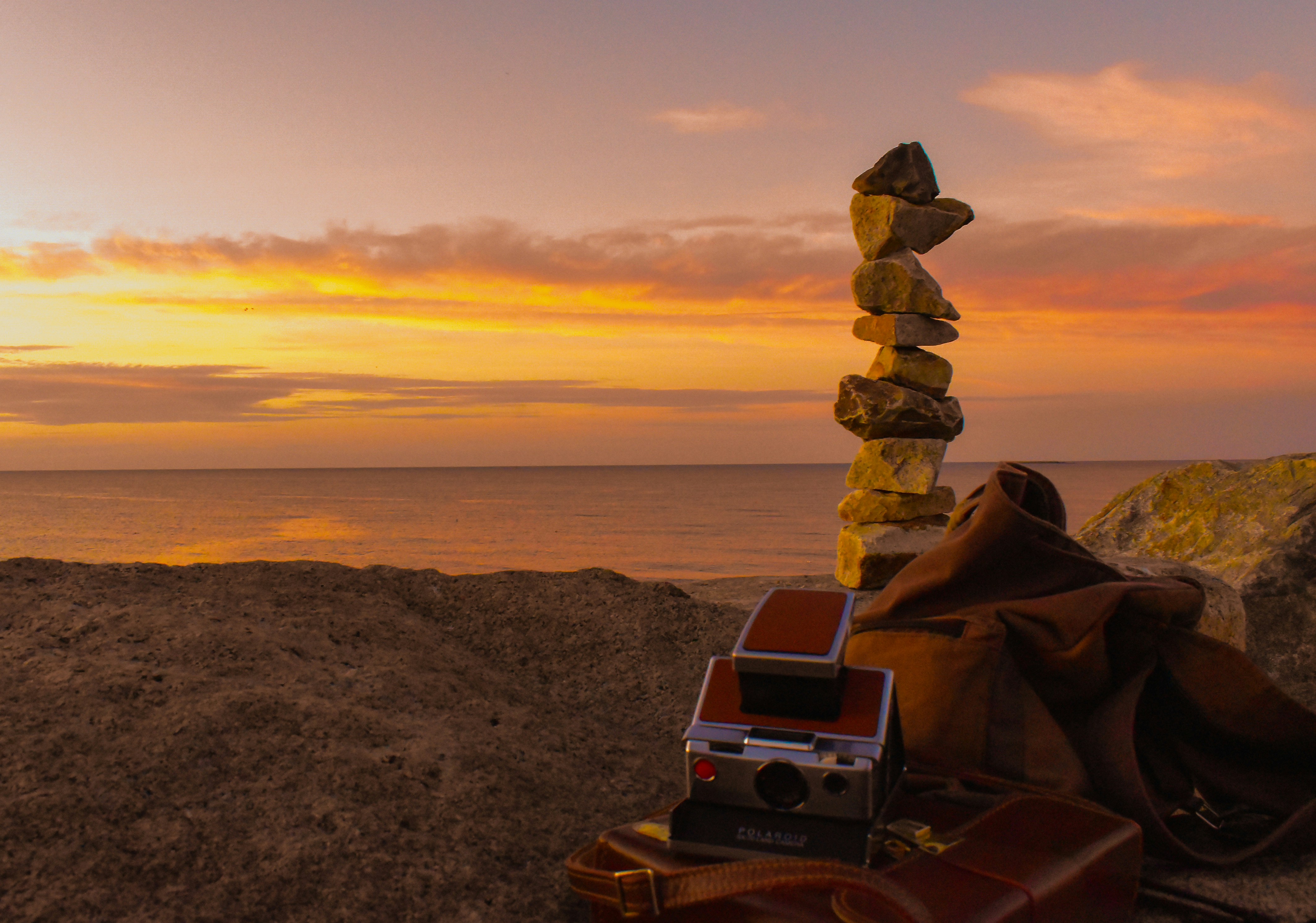 Cairn at Dusk: A Vintage Camera Watches the Sea