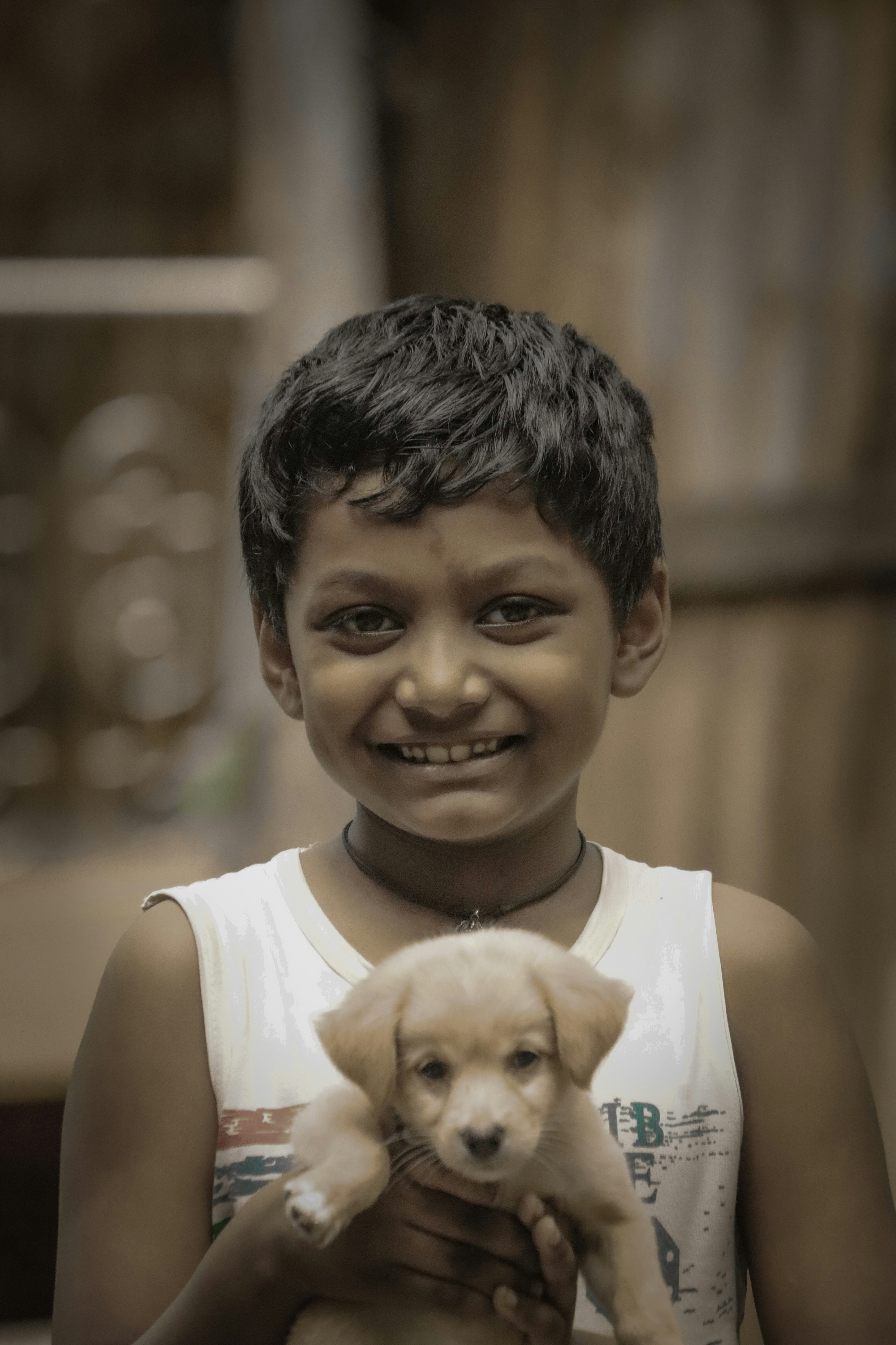 Smiling Child with Puppy: Warm Moment in a Quiet Setting