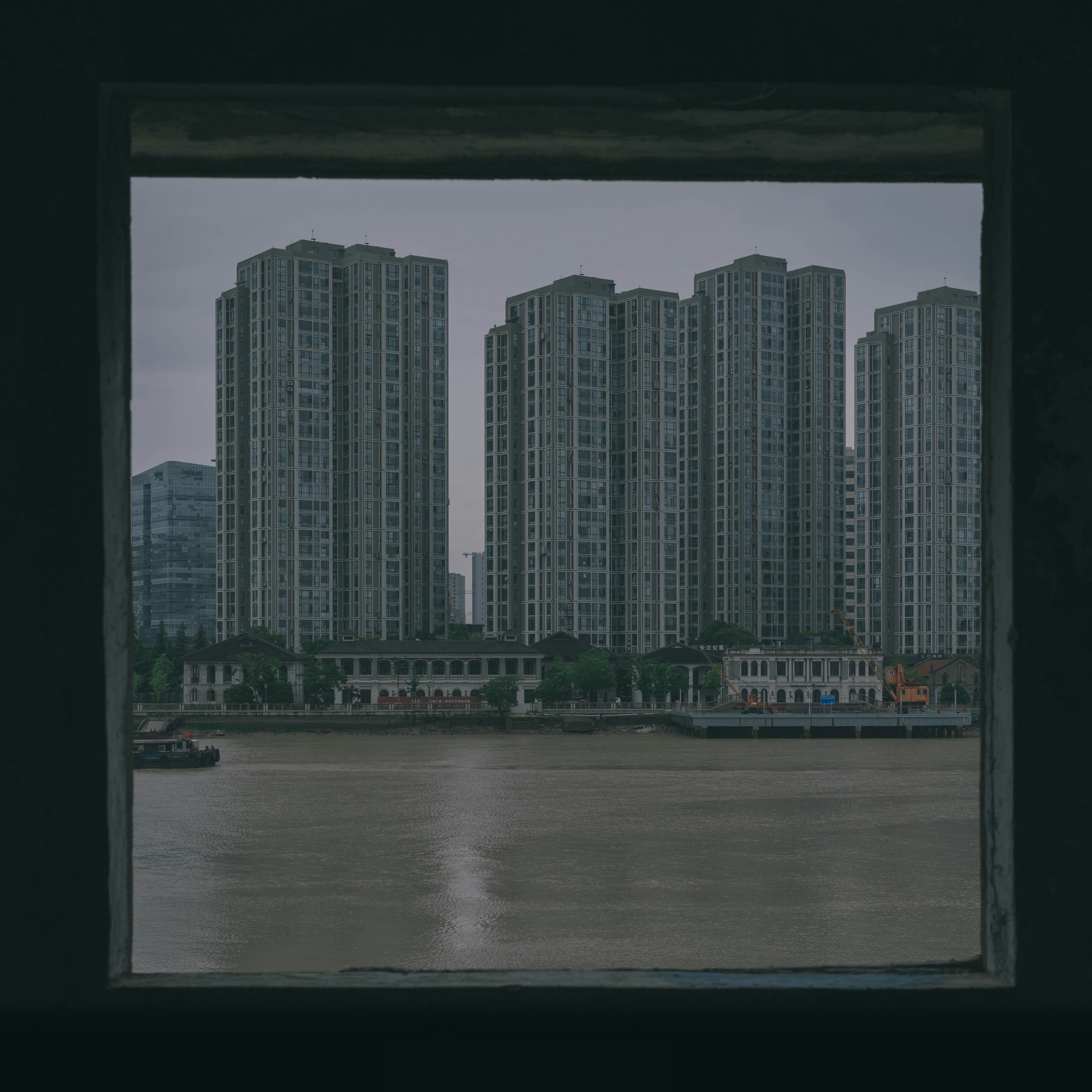 Windowed Riverside Skyline: Towers Rising Over the Riverbank