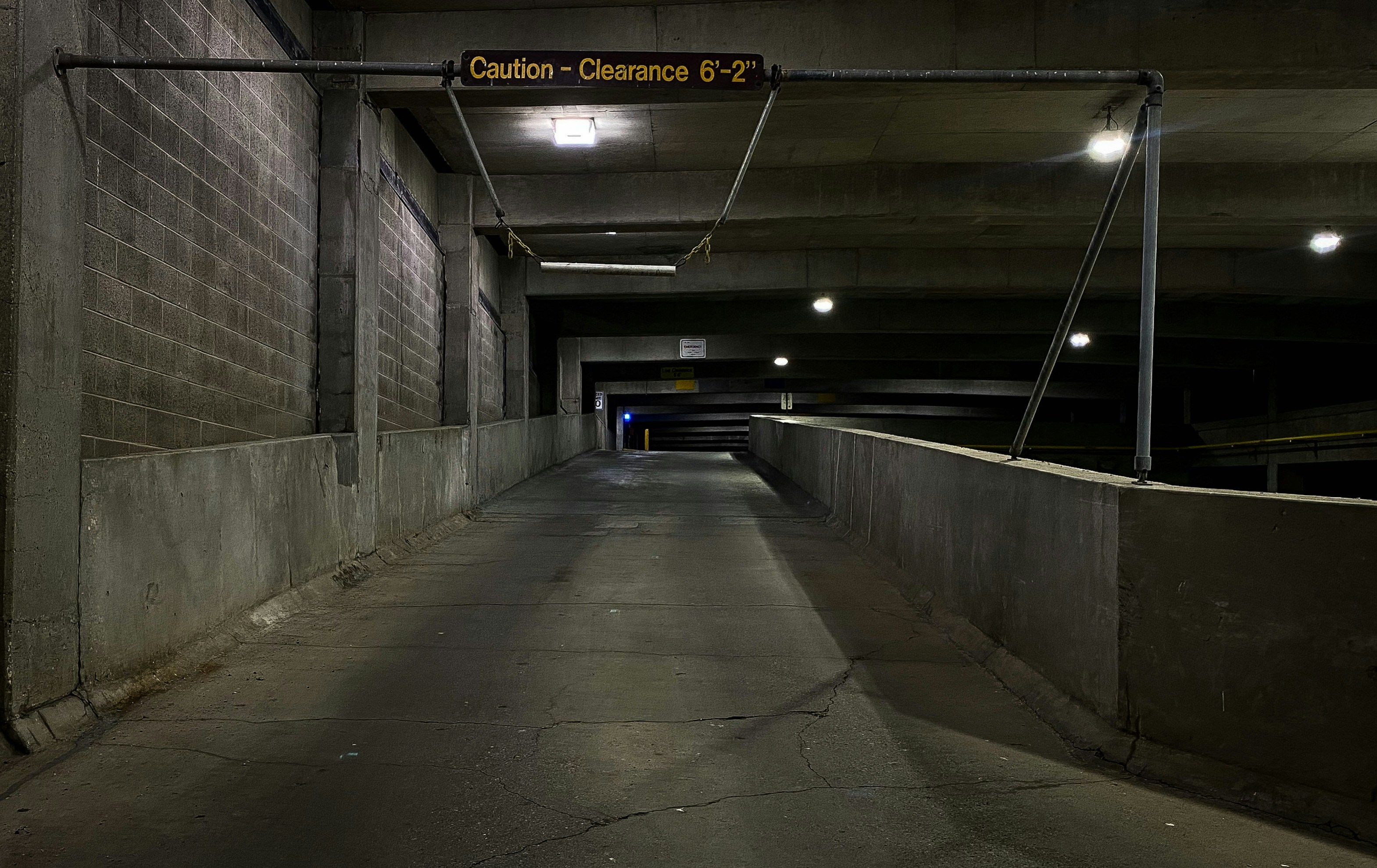 Blue Exit at the End of a Dim Parking Ramp