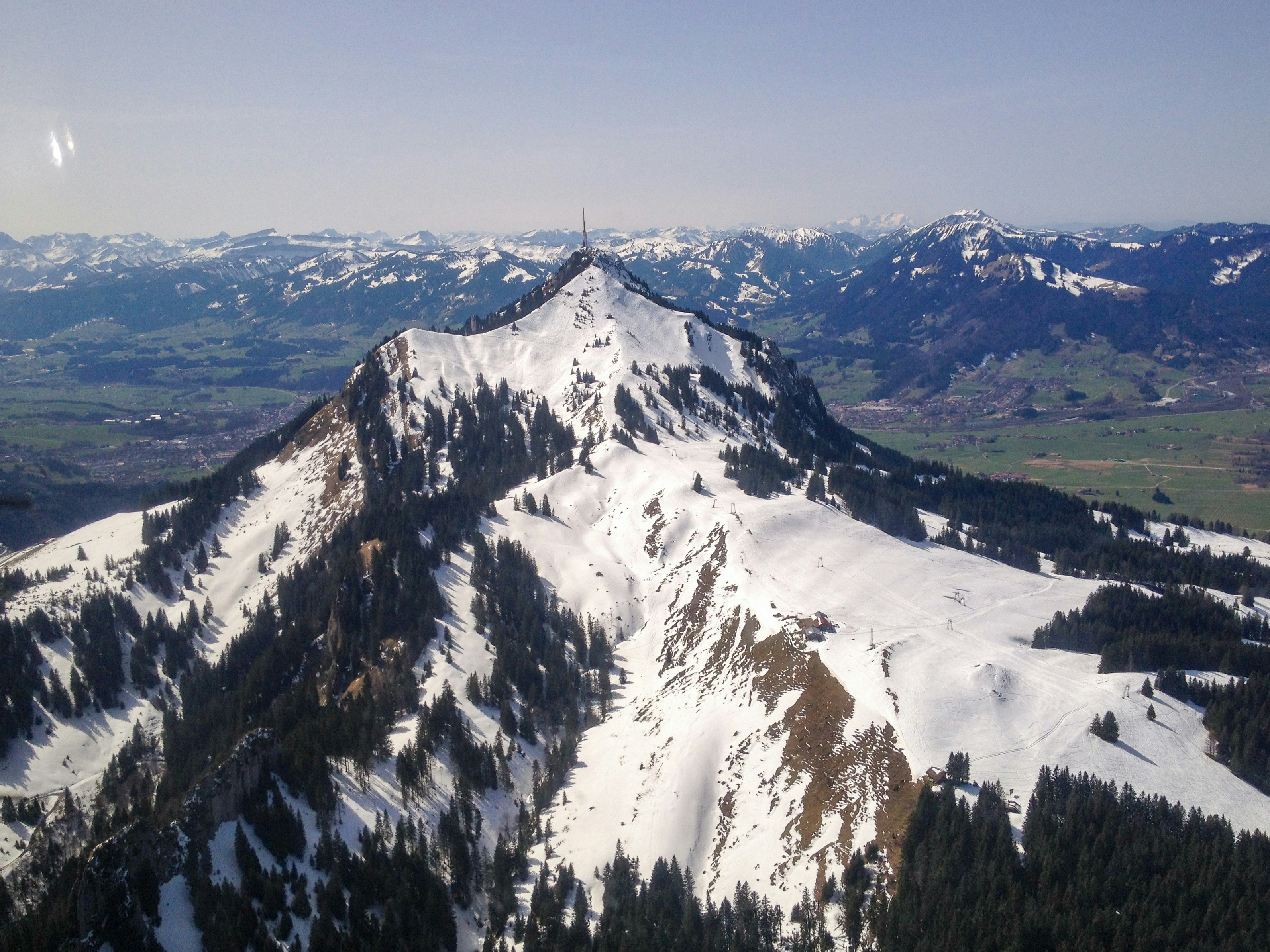 Crowned Peak: Snow and Pines Framing a Verdant Valley