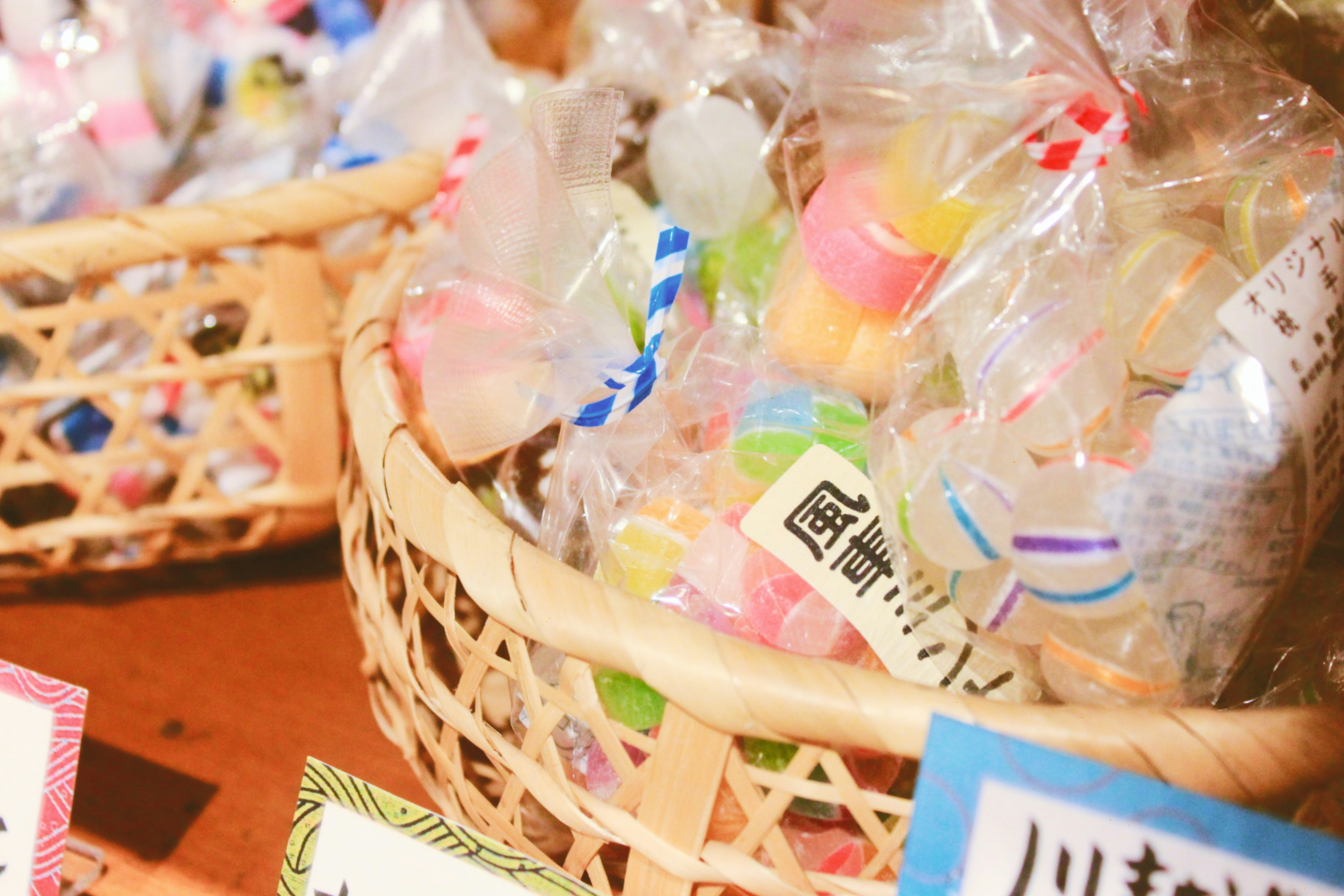Assorted candies in clear plastic bags placed in a brown woven basket.