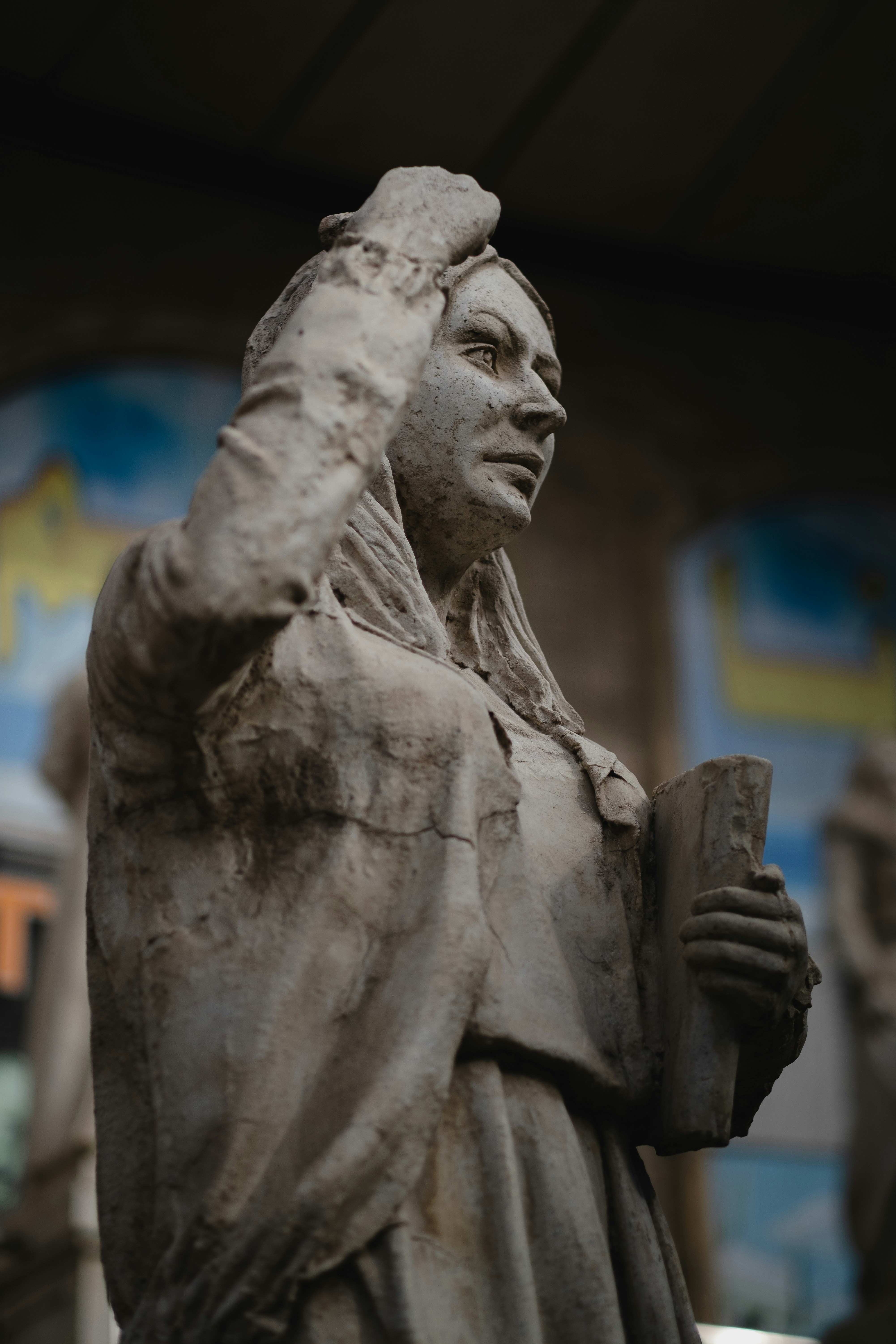 Stone Gaze Against the Blur: A Hooded Statue by Color-Washed Murals