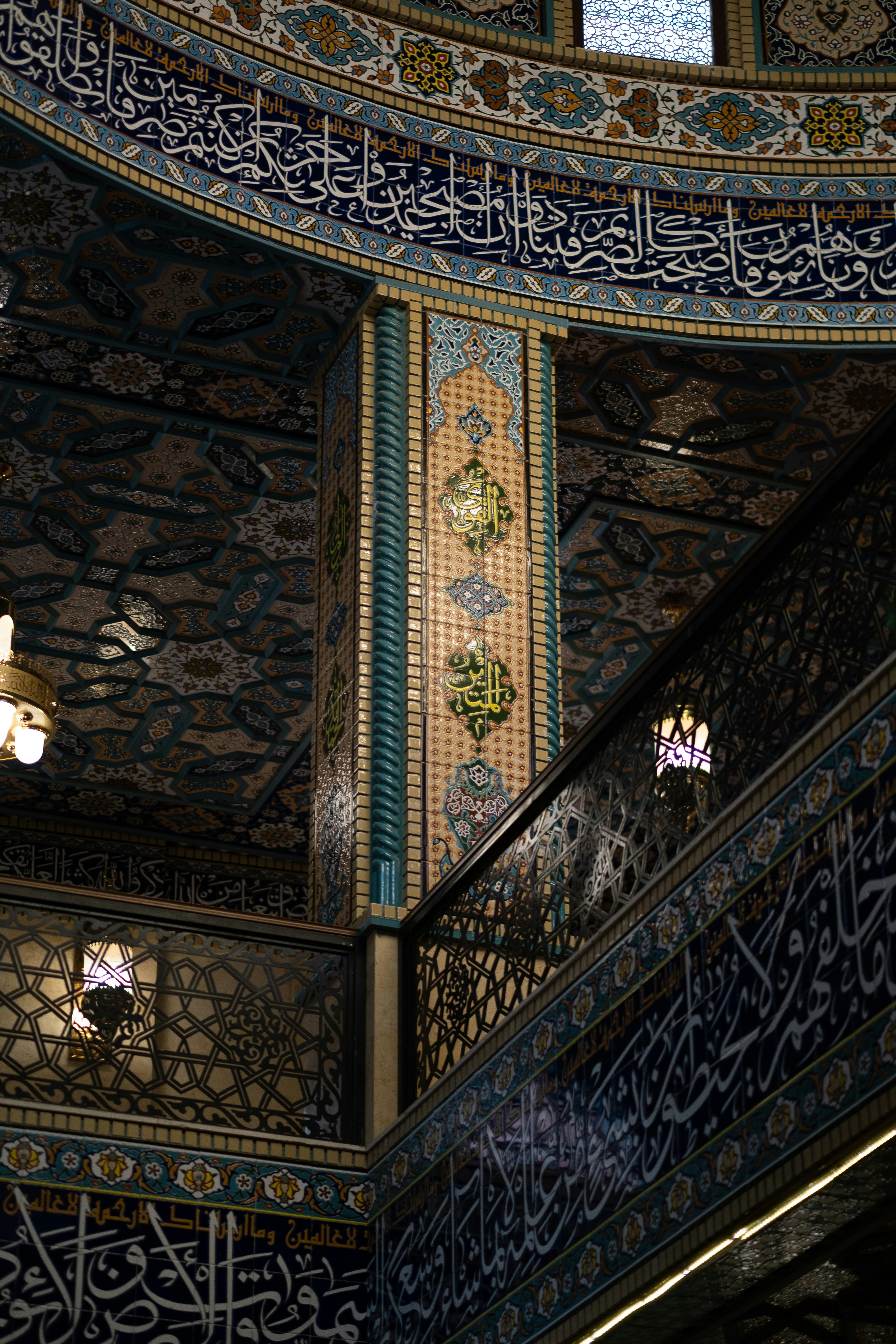 Ornate architectural details featuring intricate tile work and calligraphy in a beautifully lit interior space.