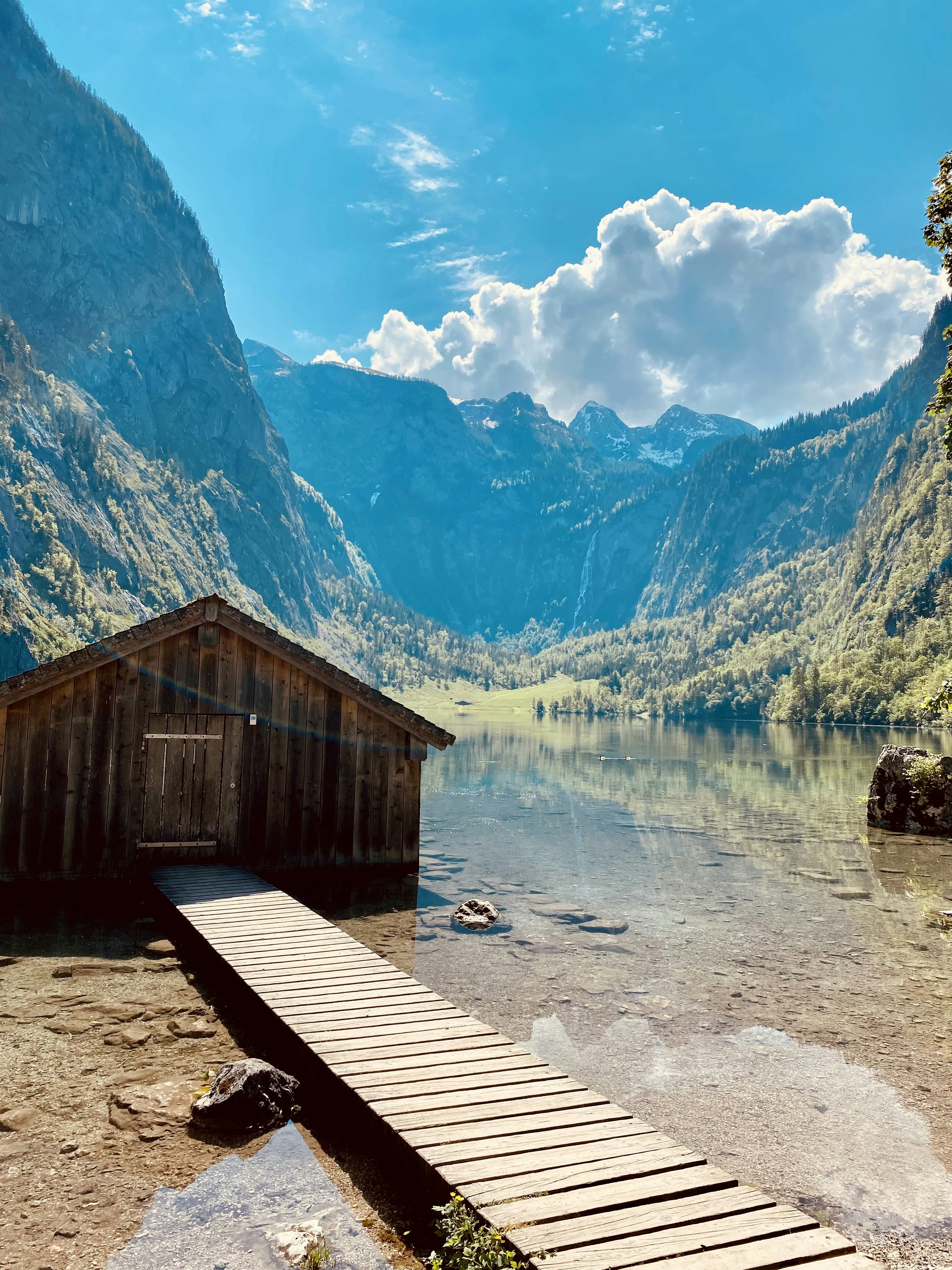 Brown wooden house near lake and mountains during daytime photo – Free ...
