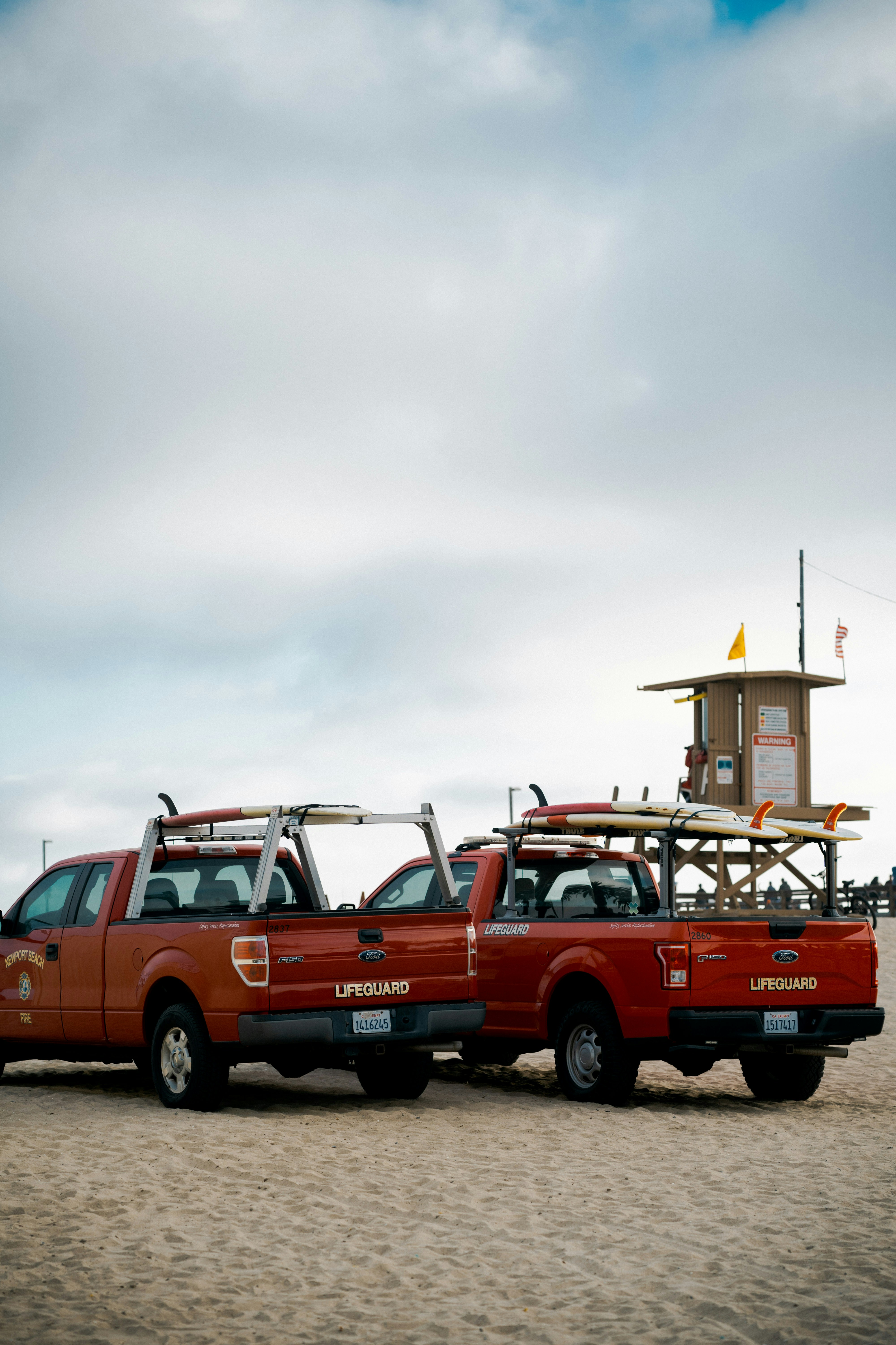 Red Lifeguard Trucks Guard the Shore: A Coastal Scene by the Lifeguard Tower