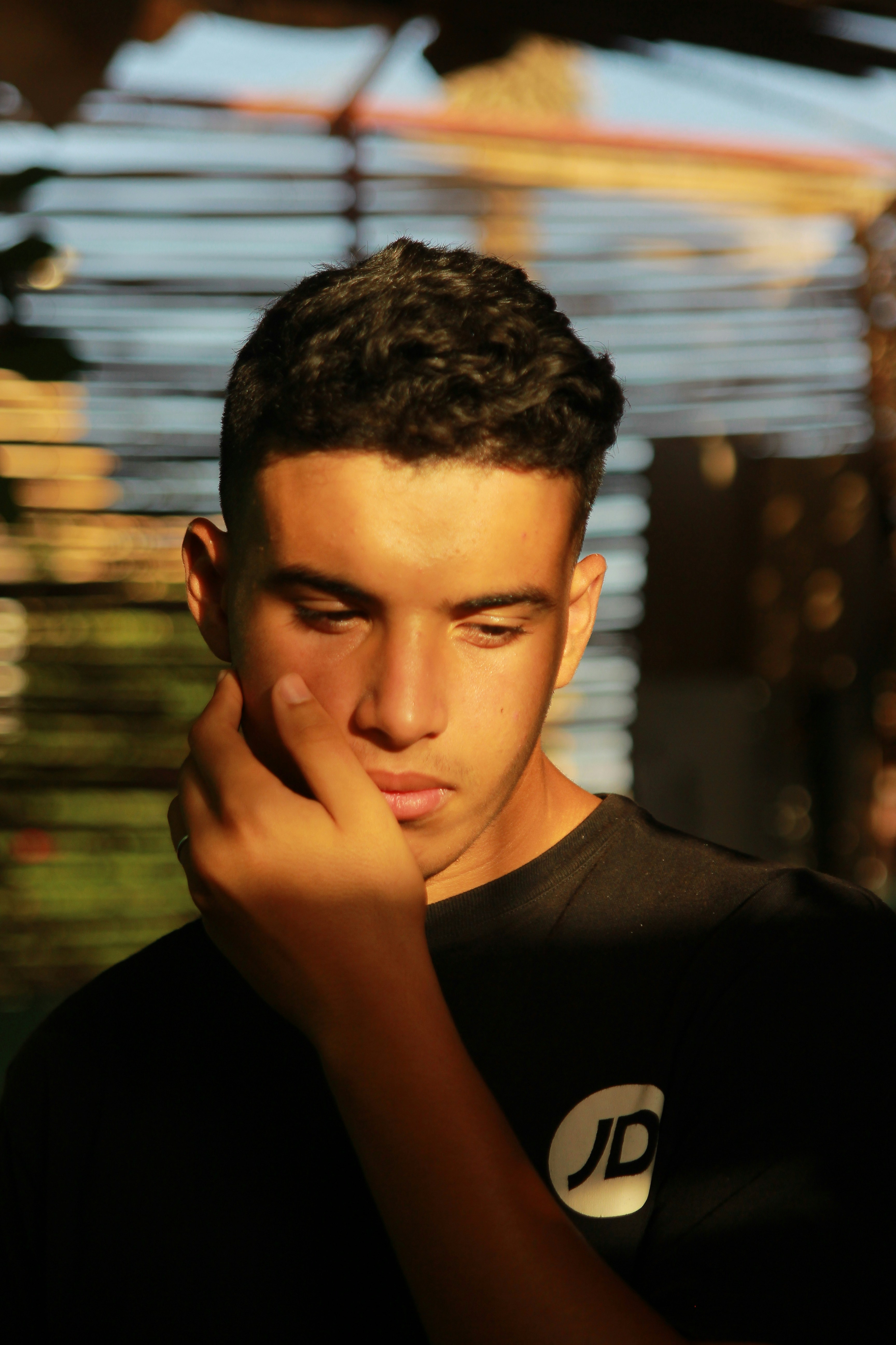 Sunlit Contemplation: Portrait of a Young Man Beneath Golden Stripes
