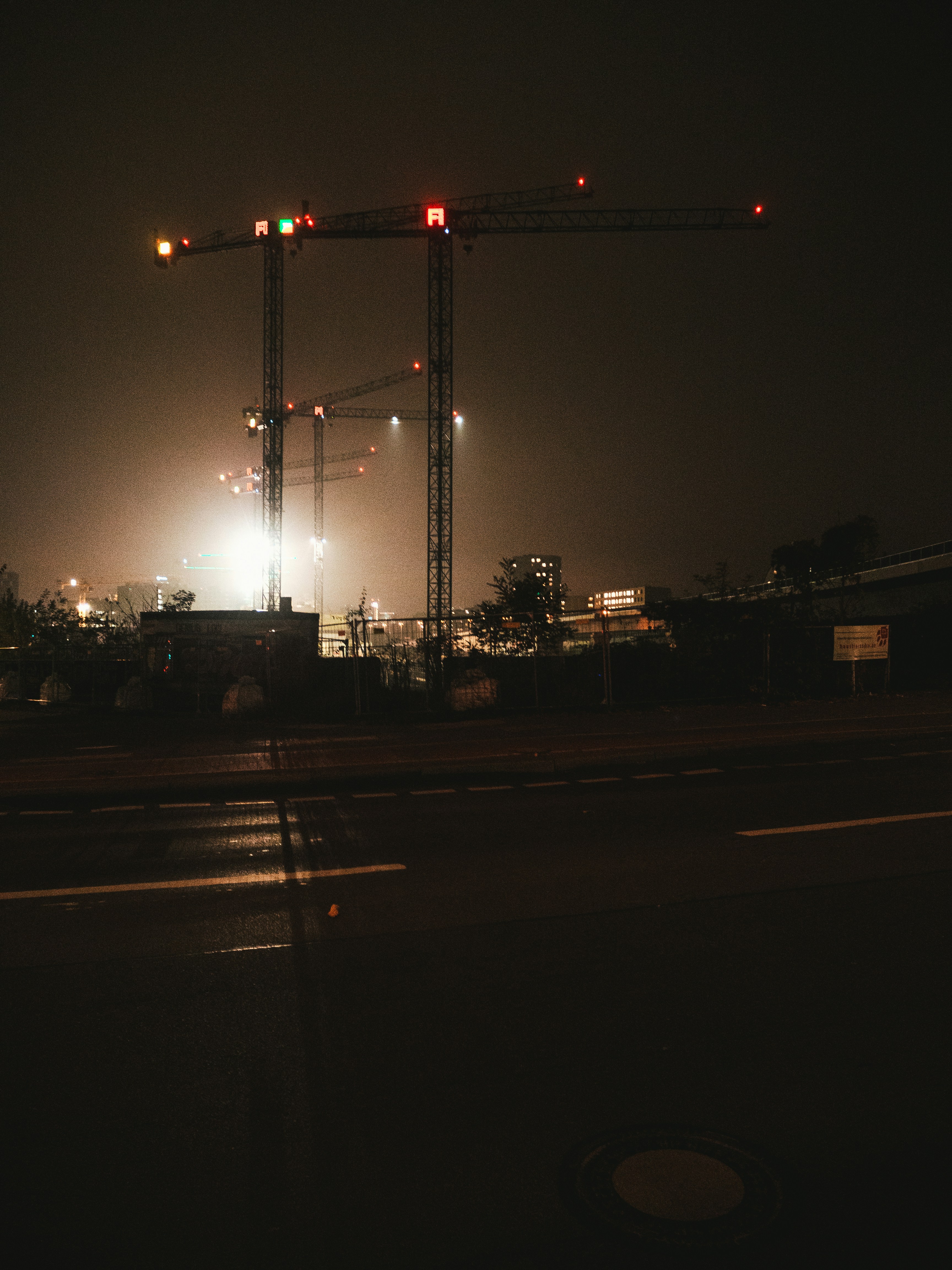 Crane Beacons in the Night: Fog Over a Quiet Construction Yard