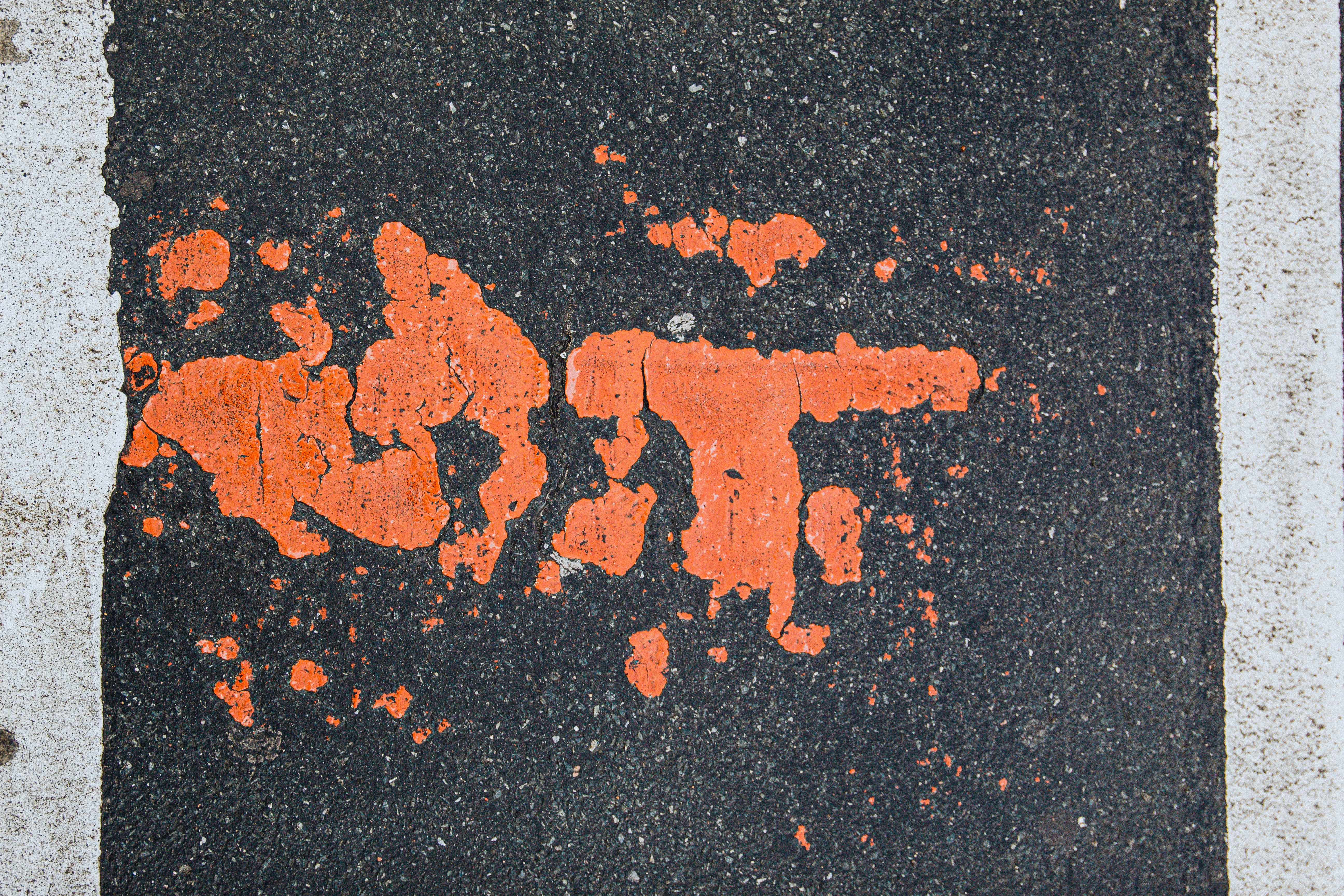 Cracked Orange: Close-Up of Weathered Asphalt Graffiti