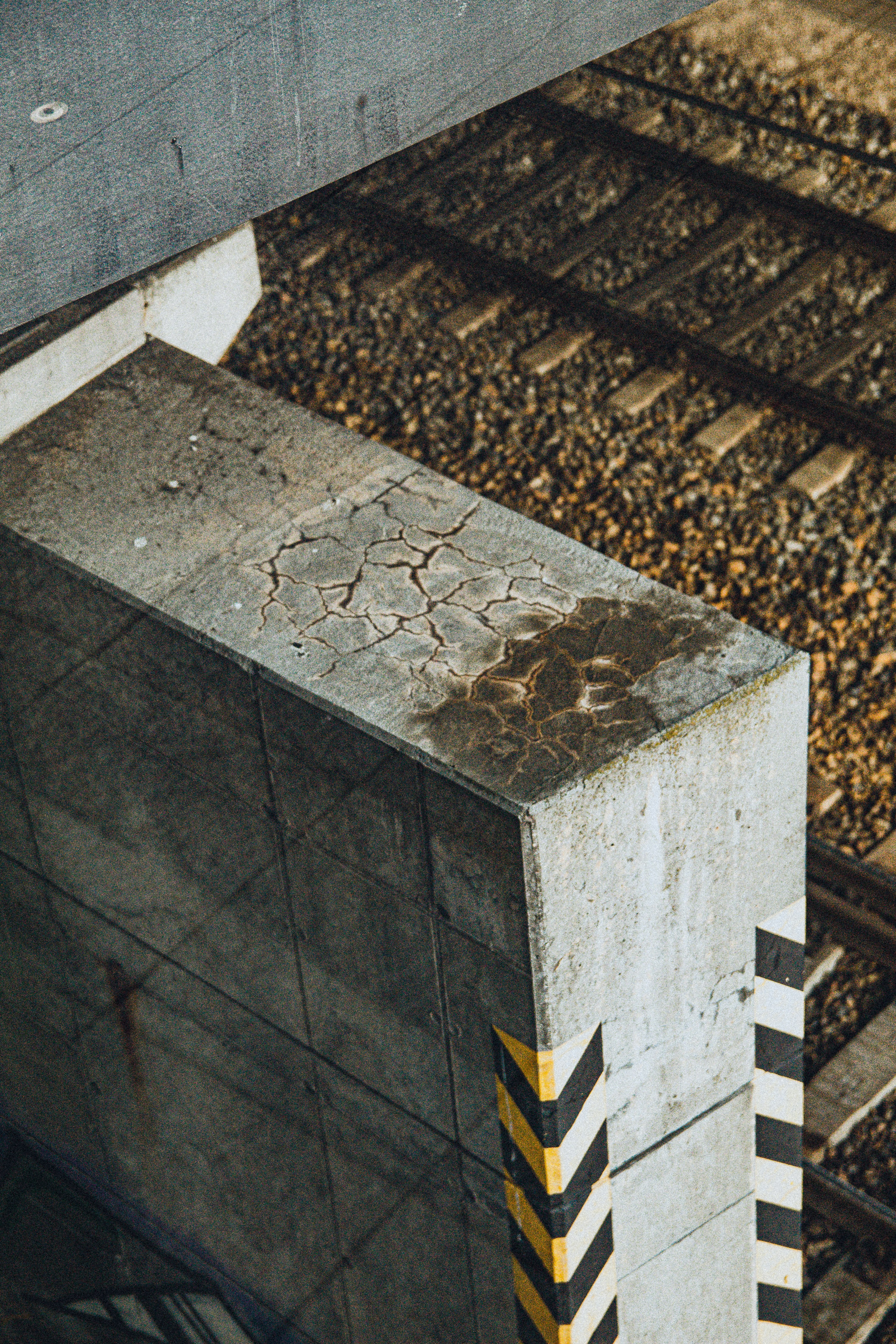 Cracked Concrete Crest Framing Rail Tracks: A Quiet Geometry of Industry