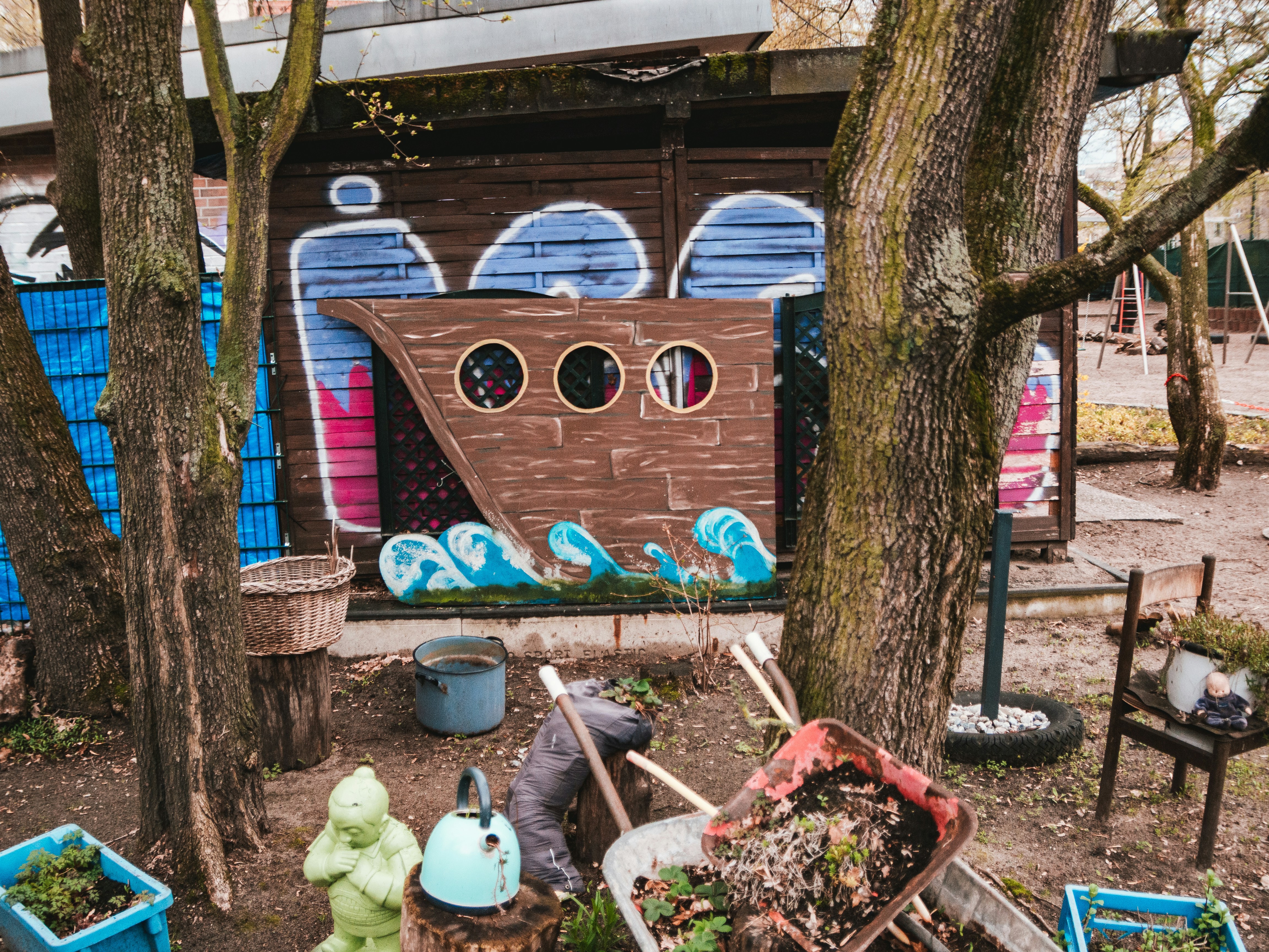 Porthole Graffiti: A Wooden Portal Framed by Trees in a Garden Yard