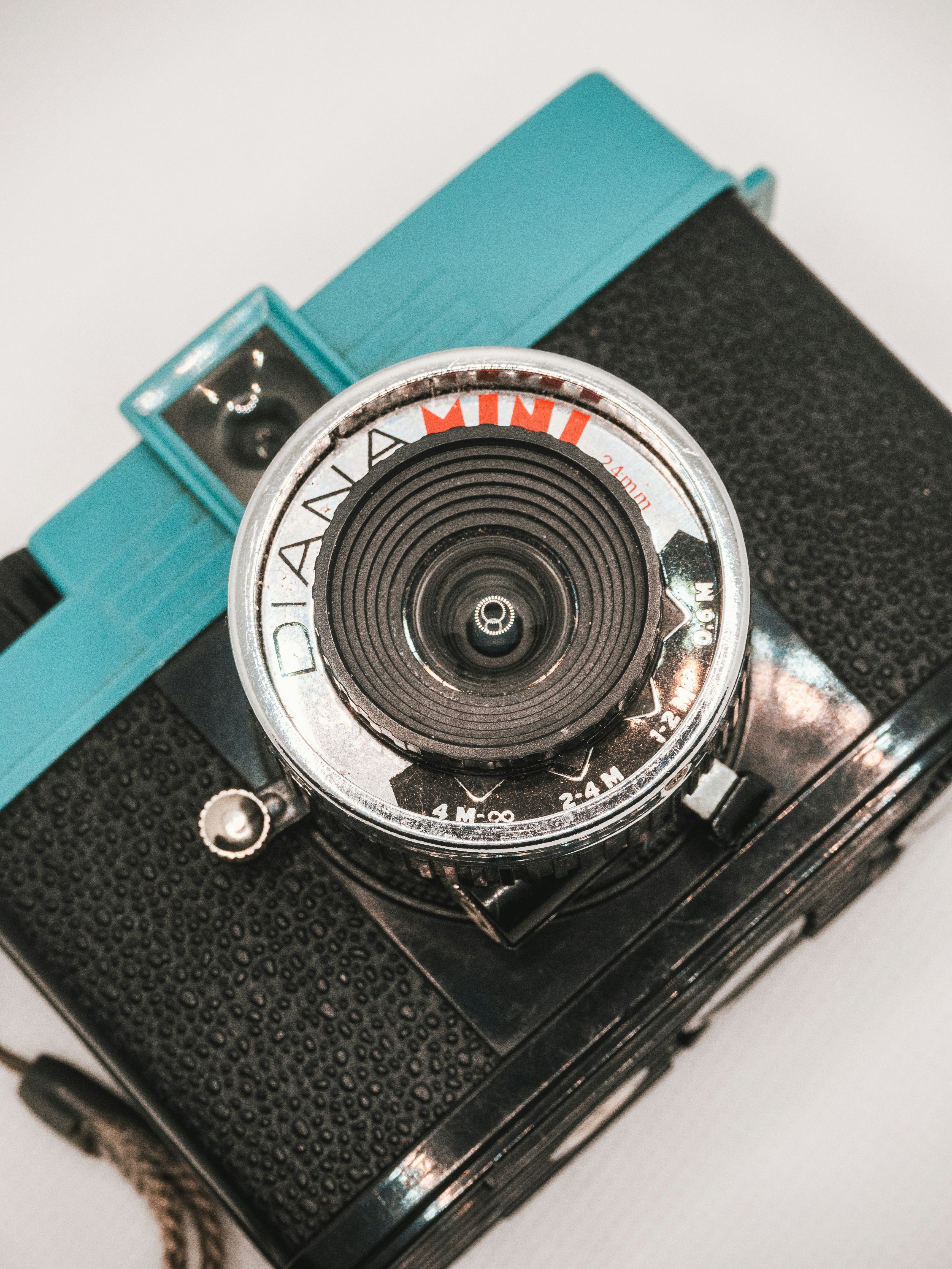 Chrome Lens Concentric: Close-Up of a Teal-Strapped Vintage Camera