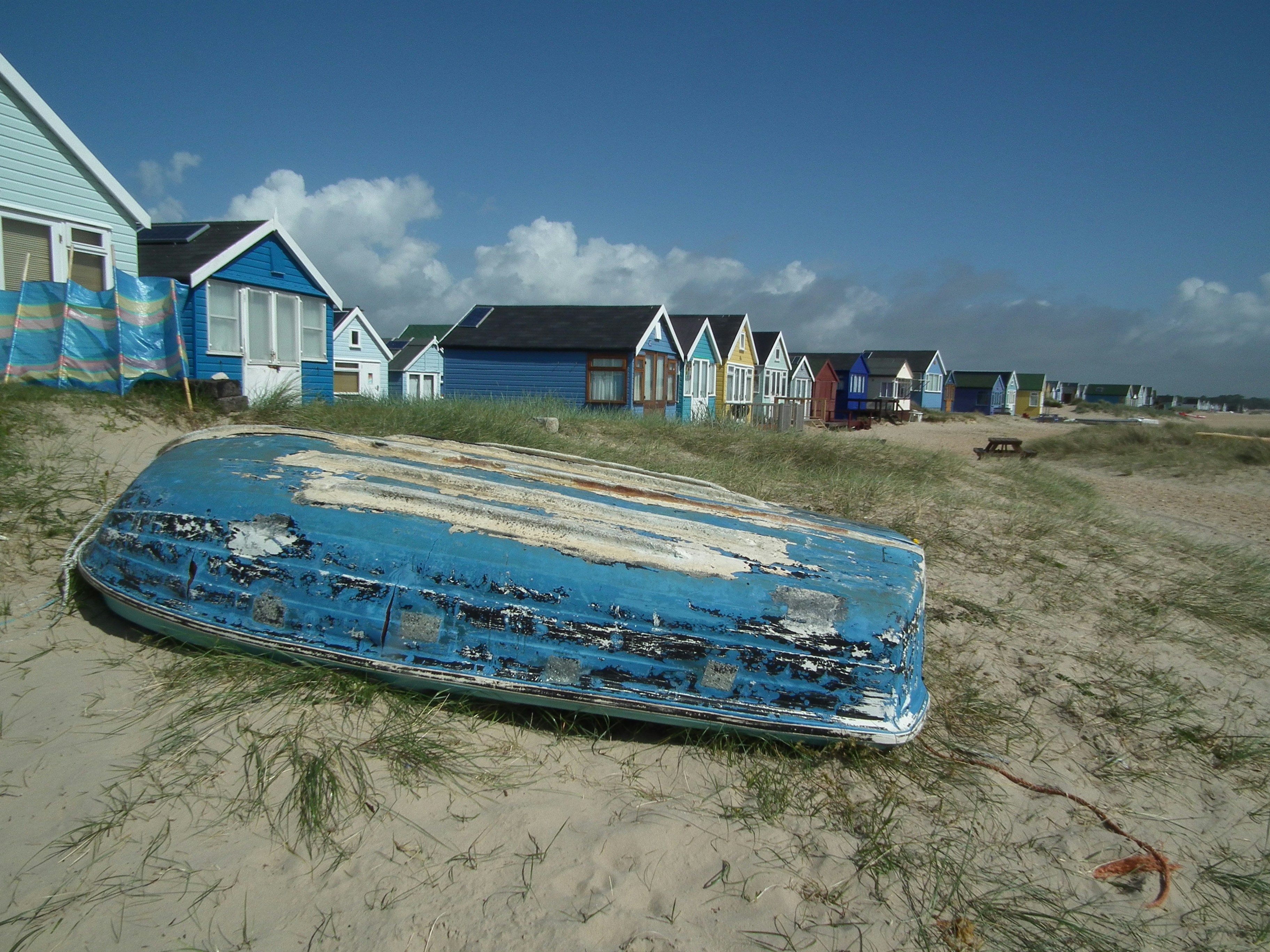 Bleached Boat in a Row of Painted Beach Cottages
