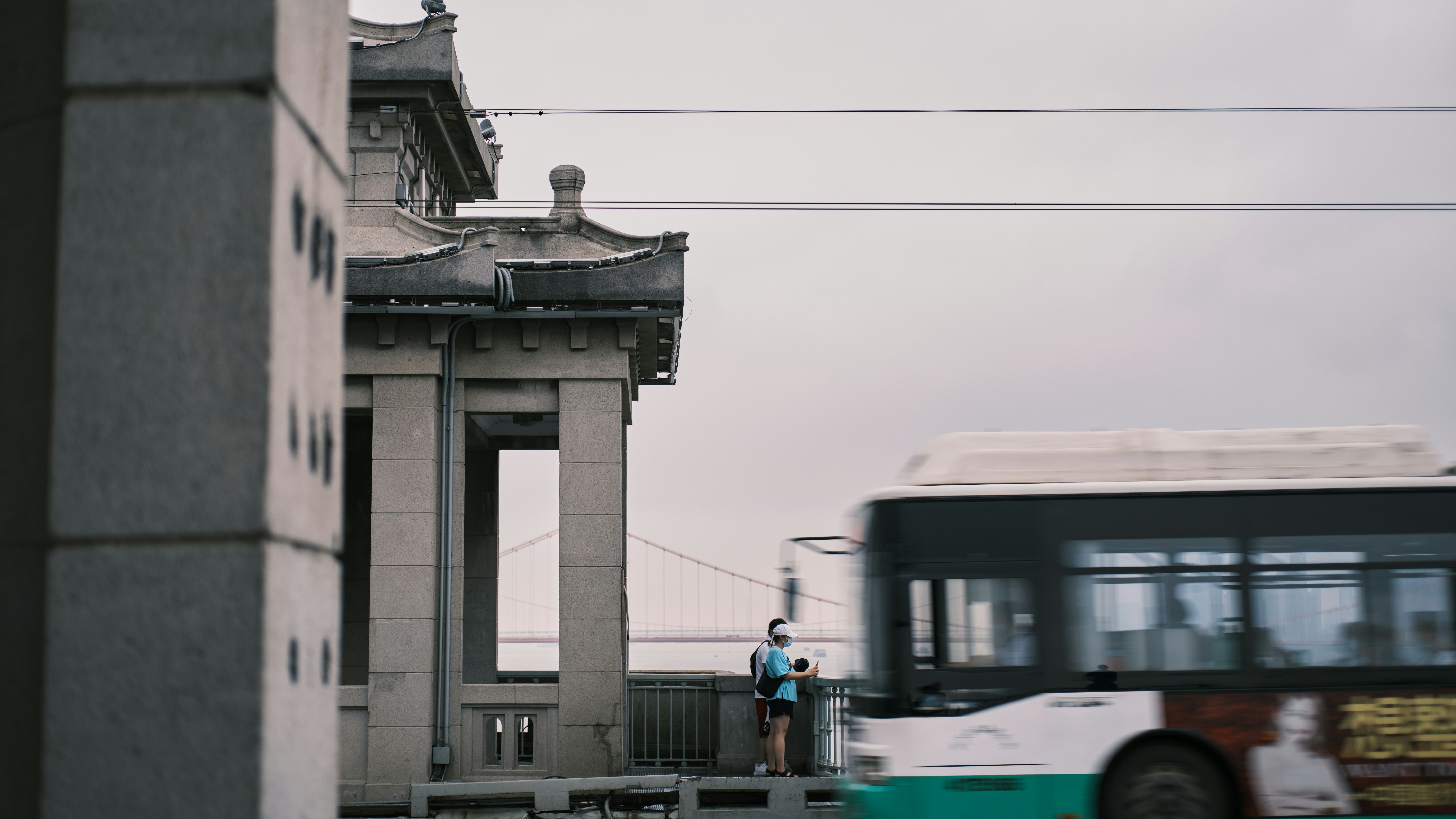 man in green jacket standing near gray concrete building during daytime