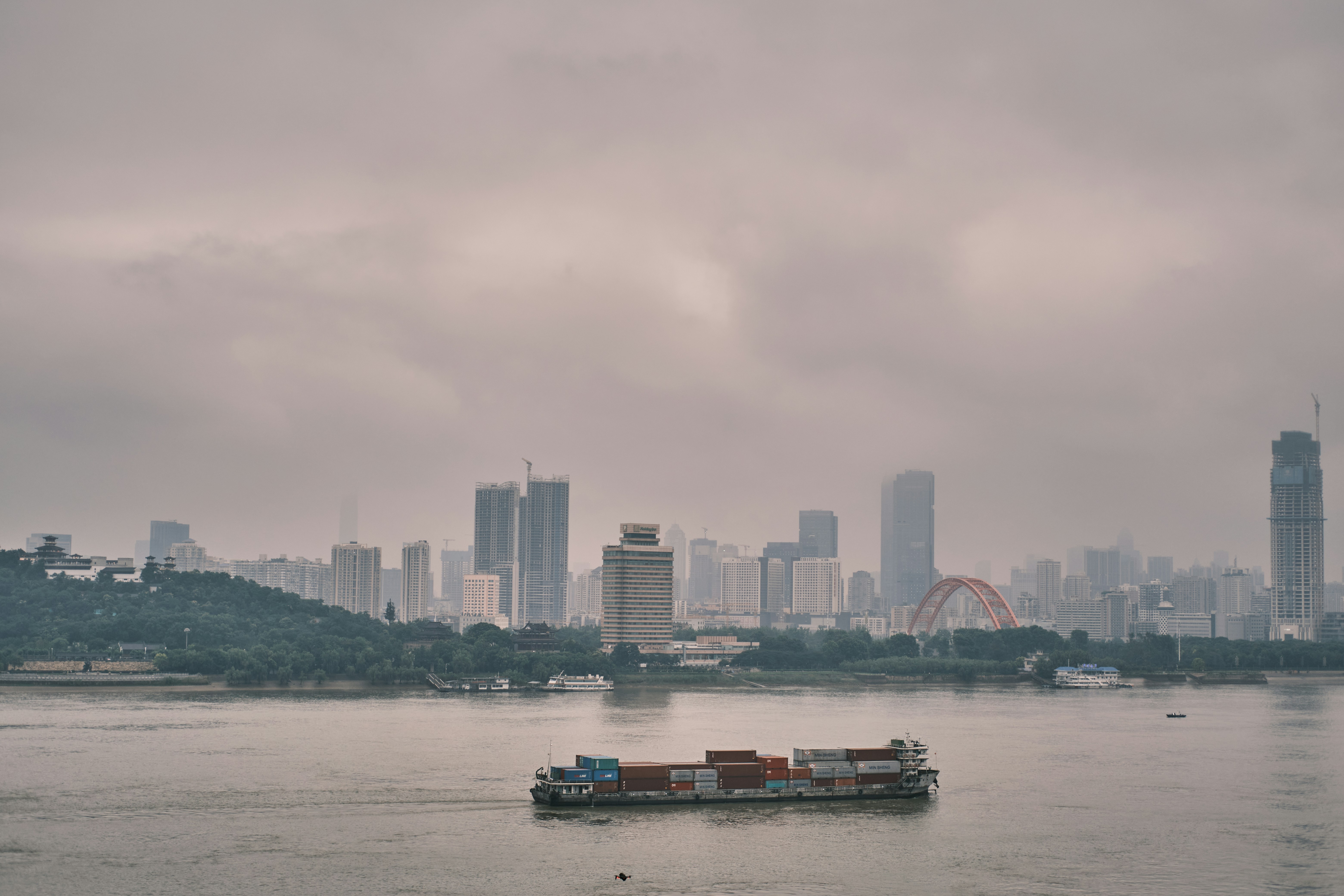 Cargo Drift on a Quiet River Beneath a Veiled City